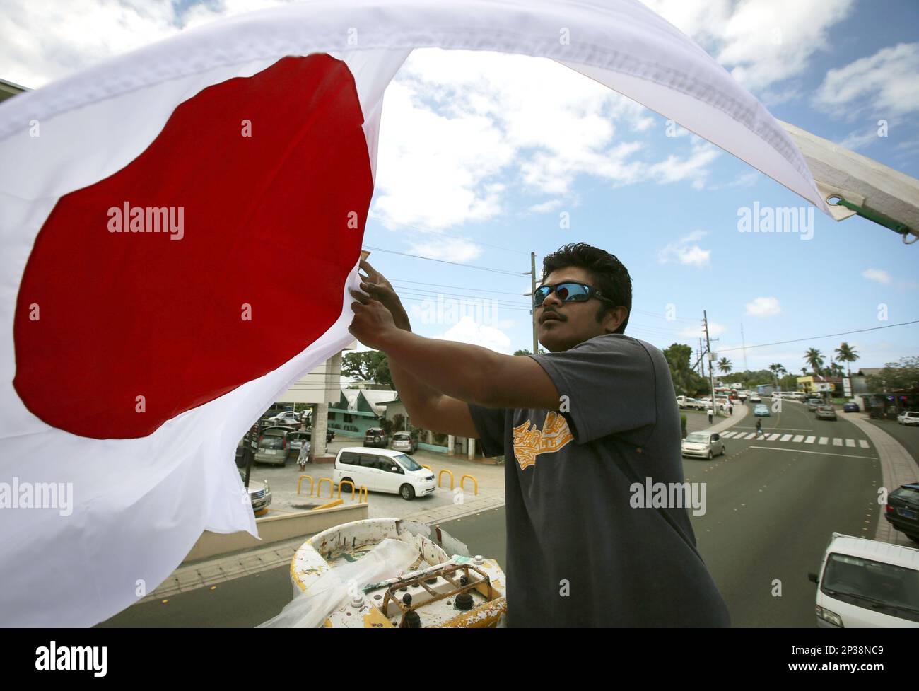 A local man prepares to set up a Japanese national flag, a hinomaru to ...