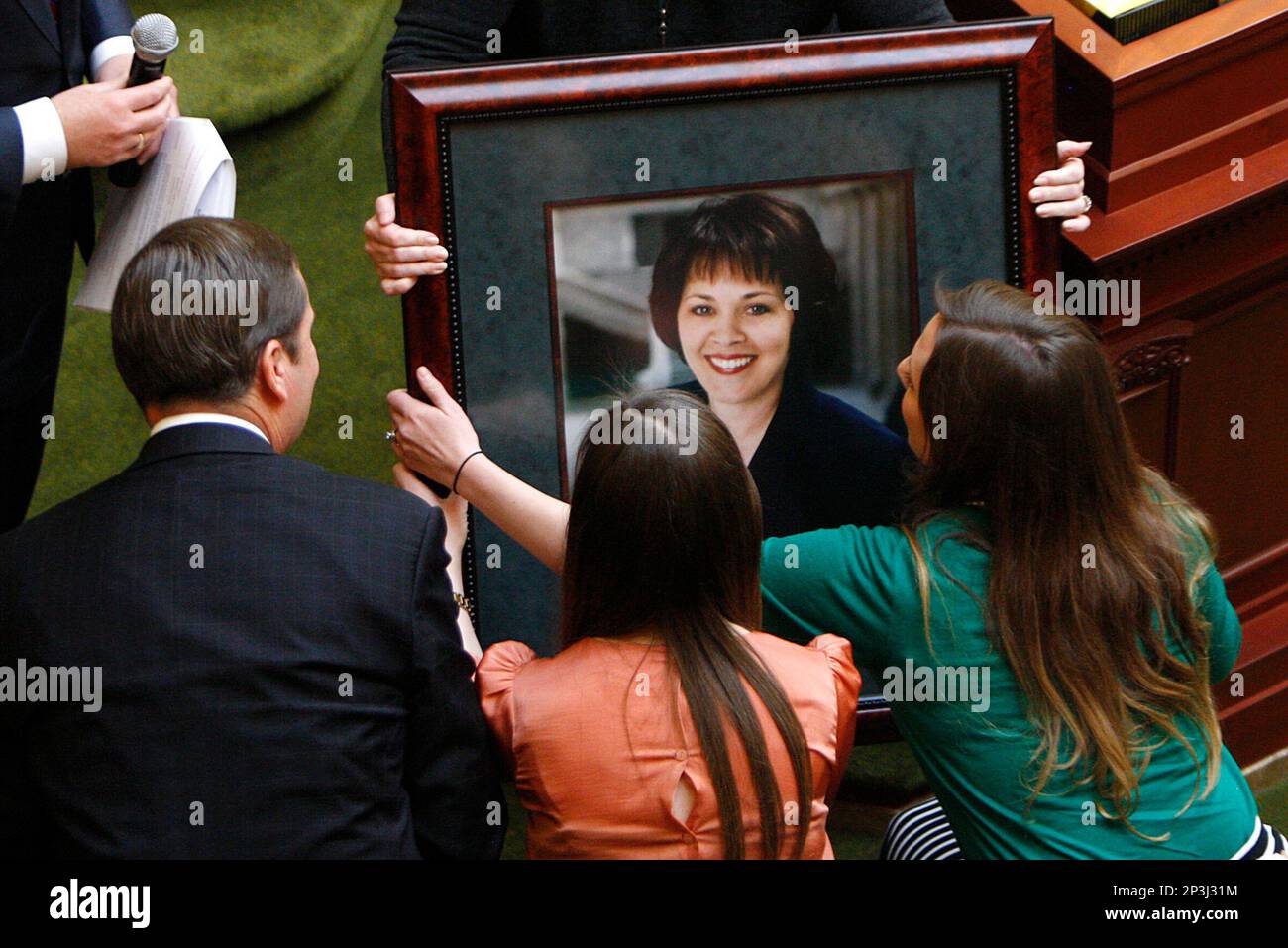 Stan Lockhart, Hannah Lockhart and Emily Britton accept a portrait in ...