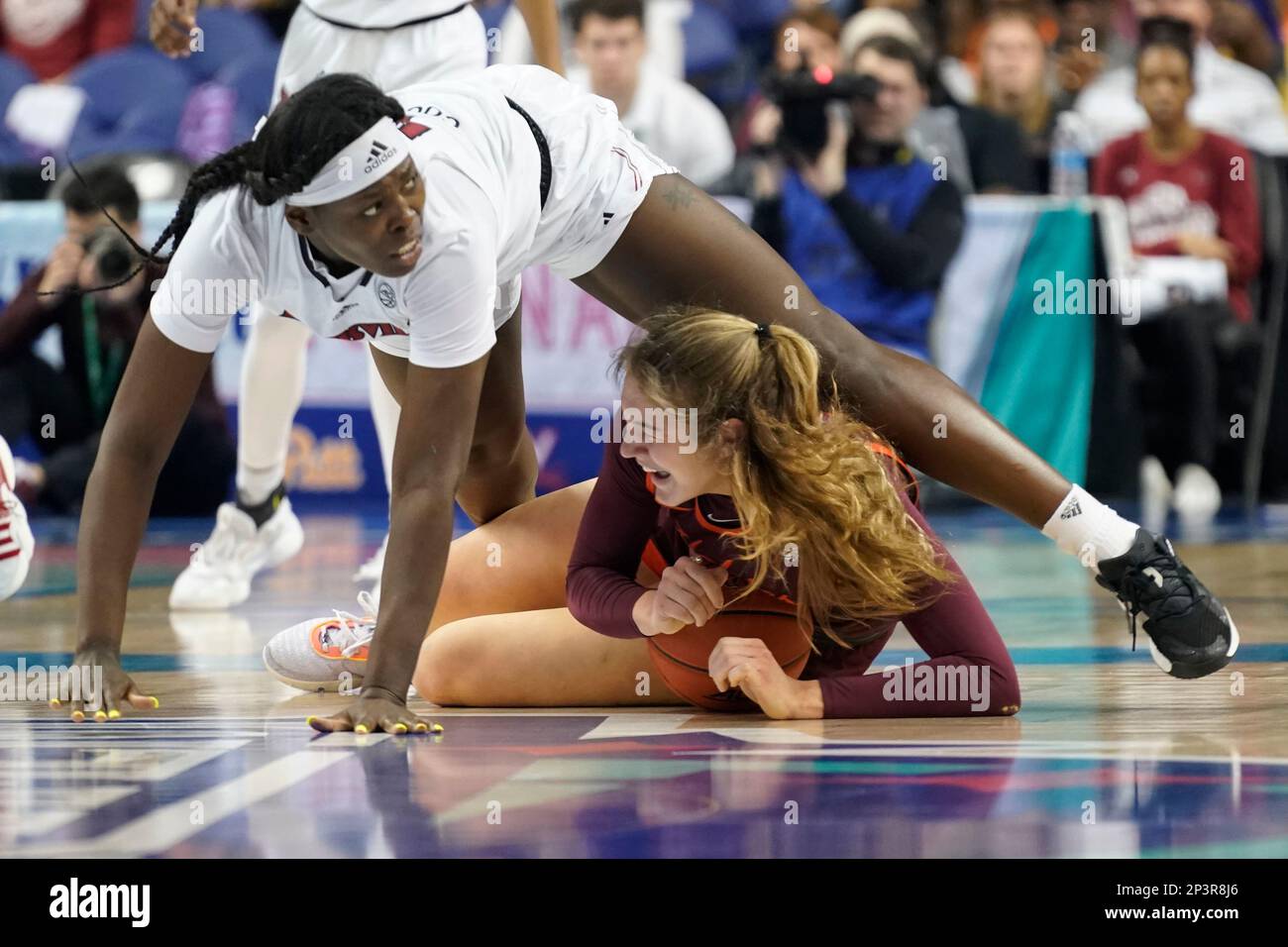 Louisville forward Olivia Cochran, top, falls over Virginia Tech center ...