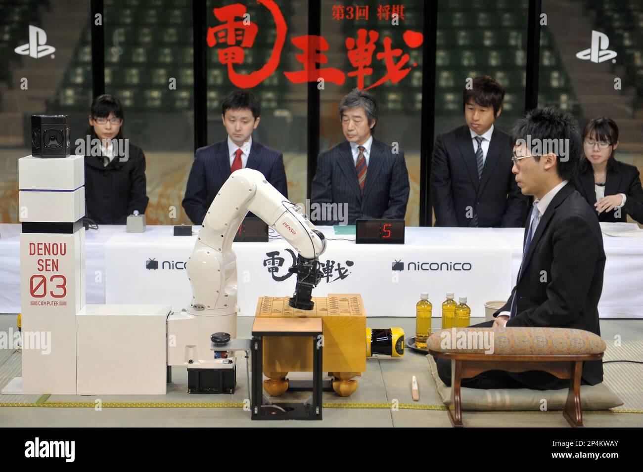 A shogi (Japanese chess) playing robot arm faces a professional player ...