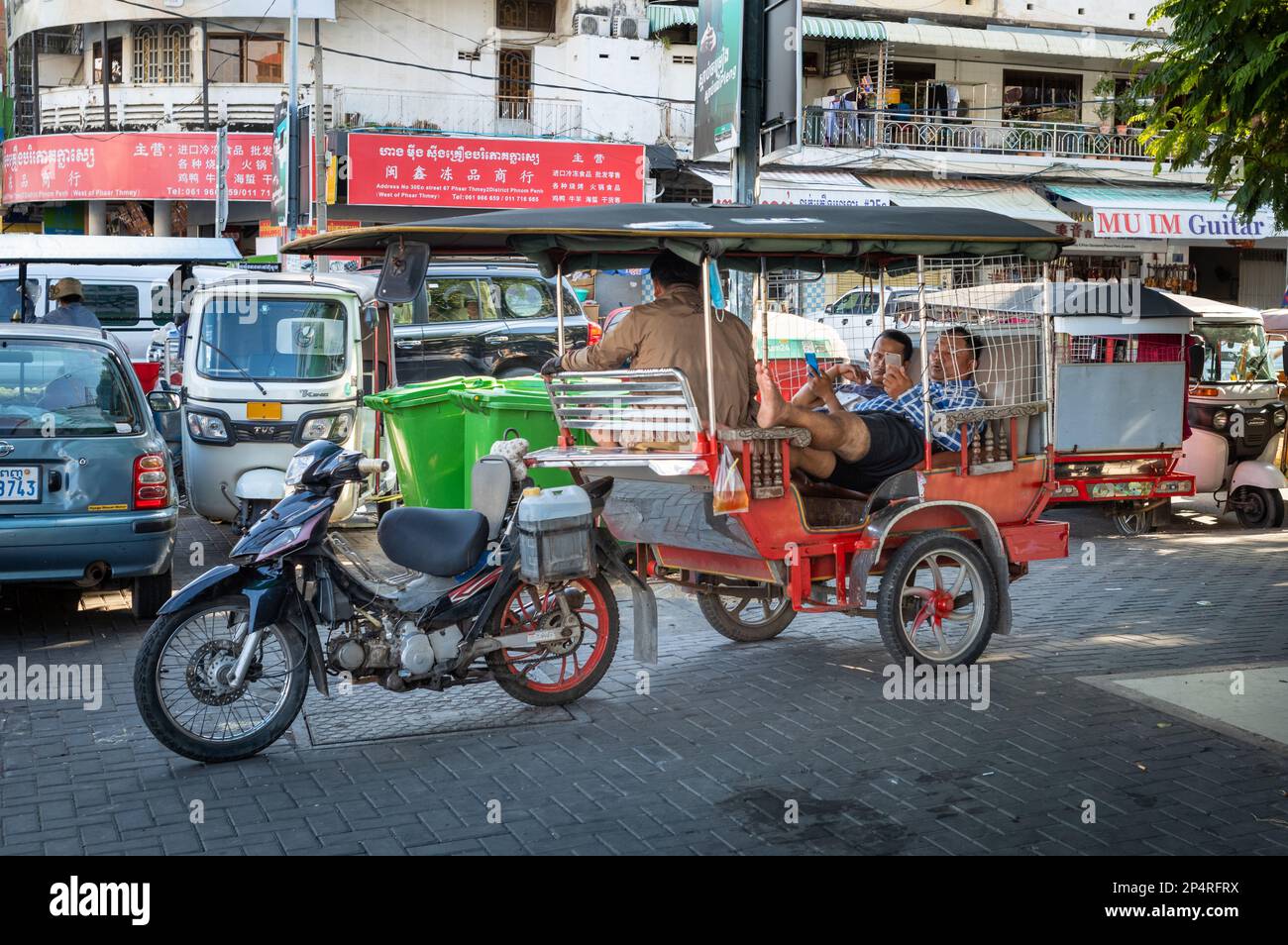 Les chauffeurs de taxi de la remorque de la moto sont assis à l'arrière ...