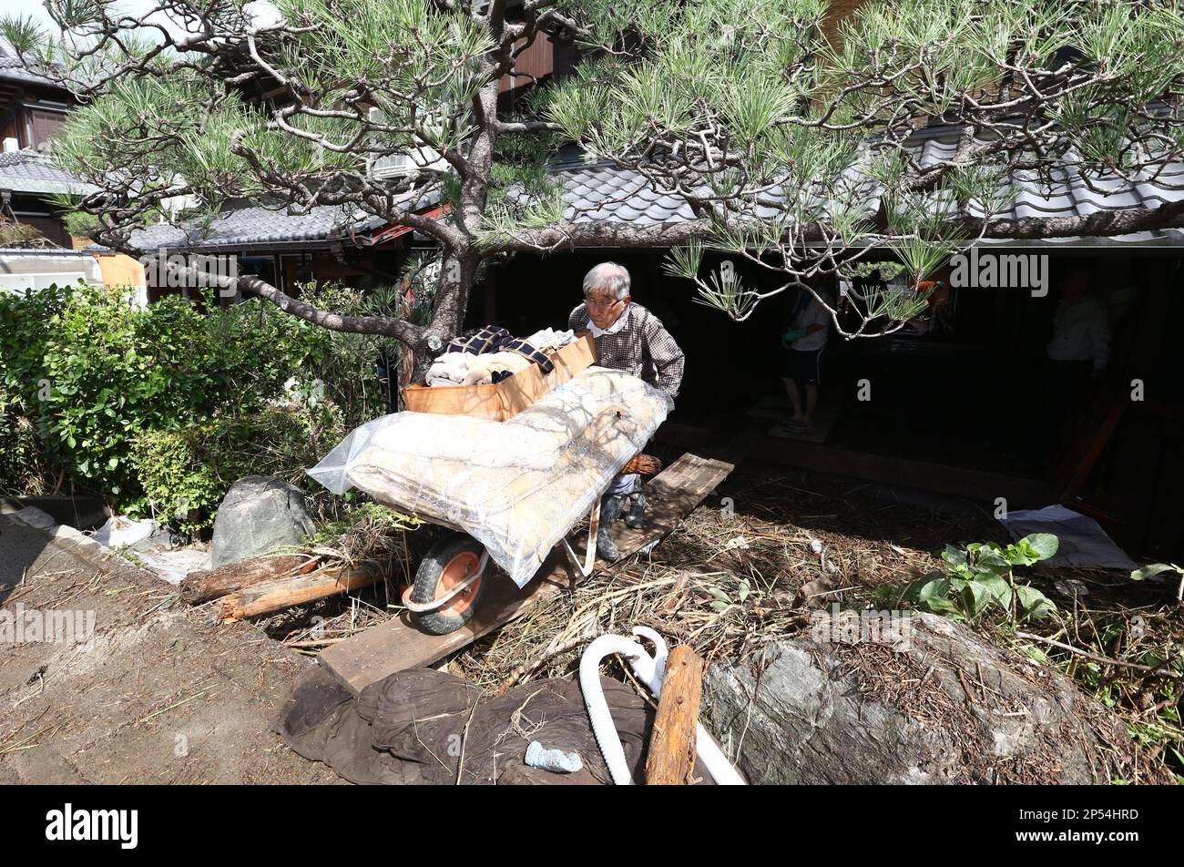 A woman removes her belonings from houses damaged by the typhoon No. 18 ...