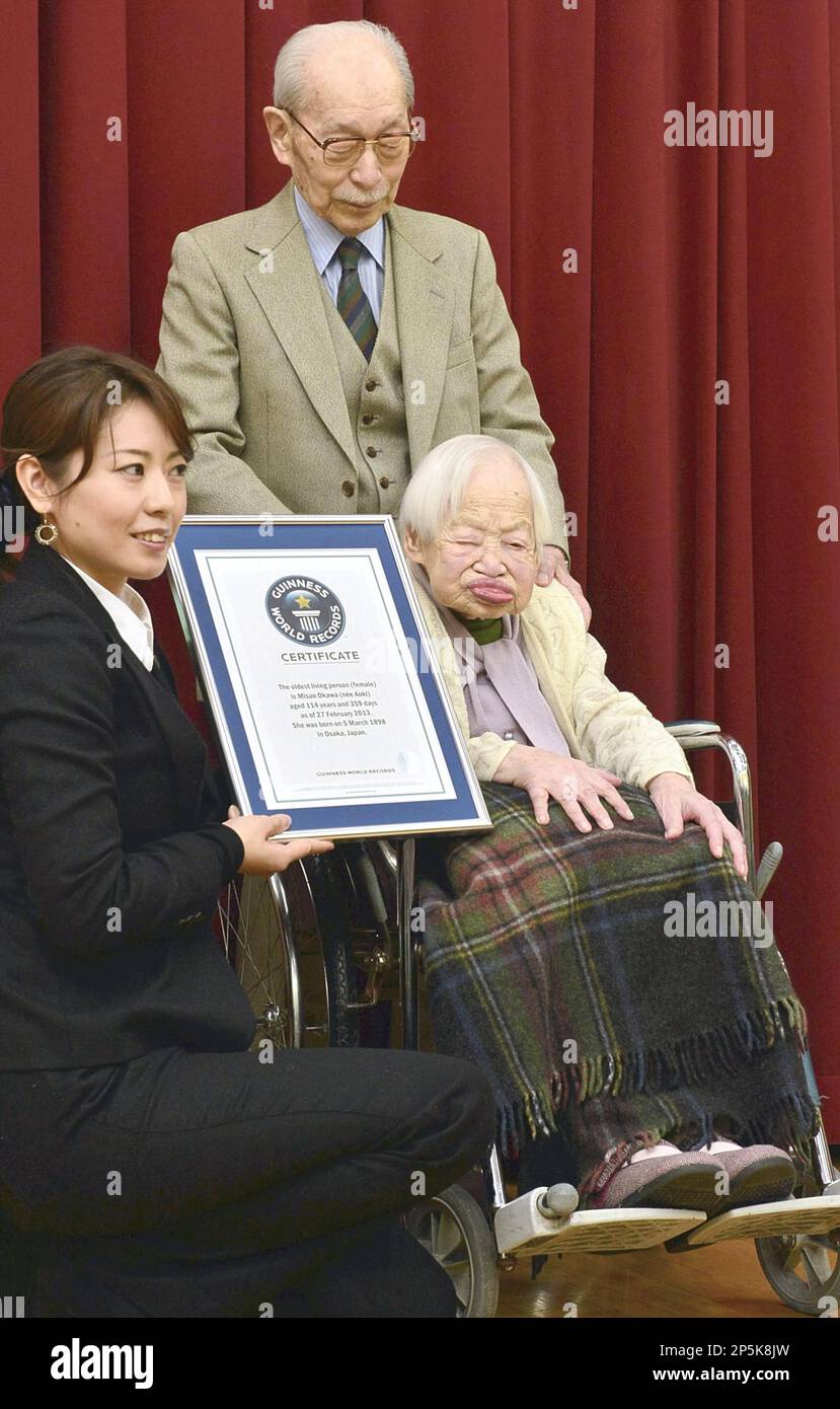114-year-old Japanese woman Misao Okawa (wheelchaired) poses with her 90-year-old son Hiroshi as ...