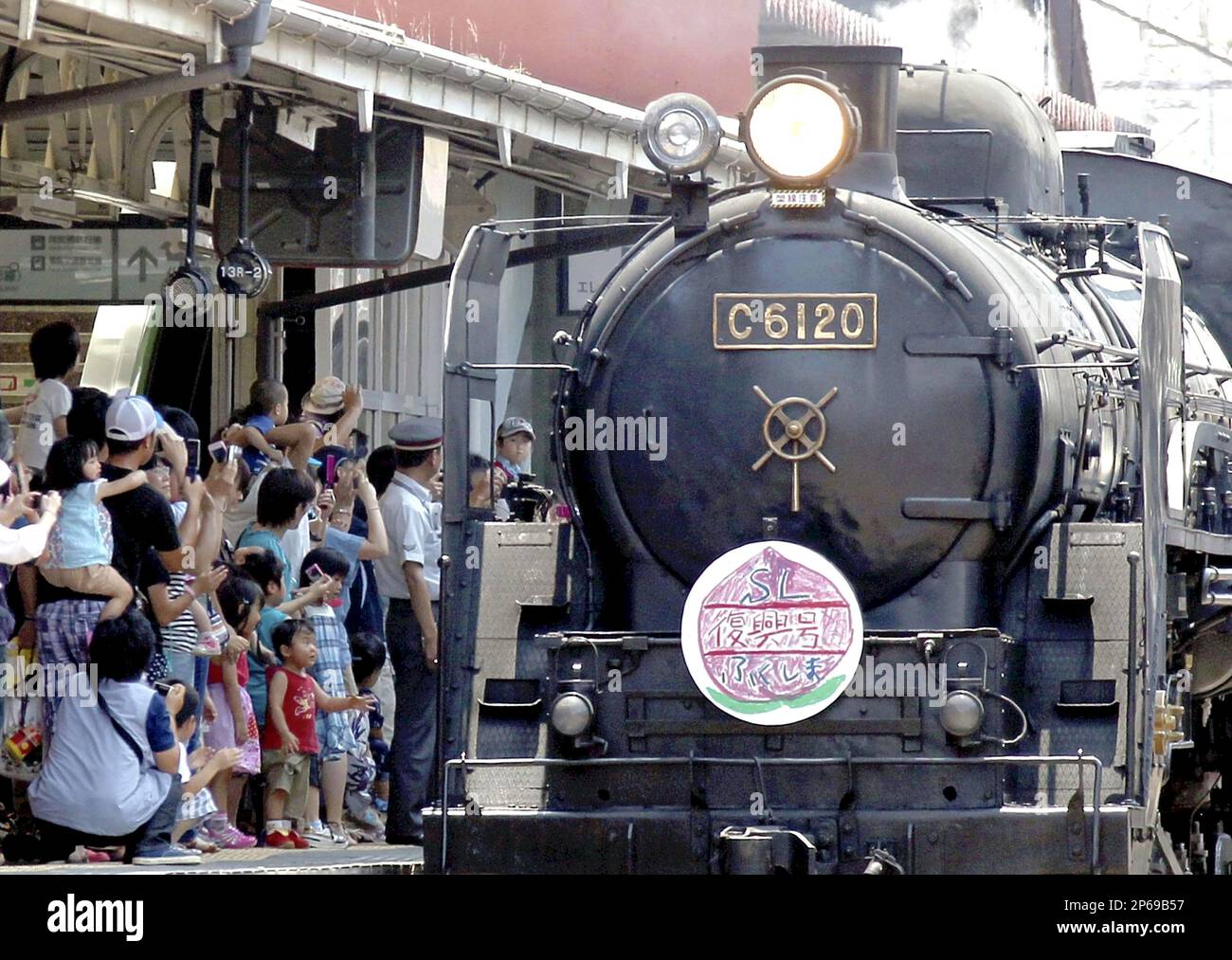 Railway fans take photos of the C61 steam locomotive at JR Koriyama Station on July 28, 2012 ...