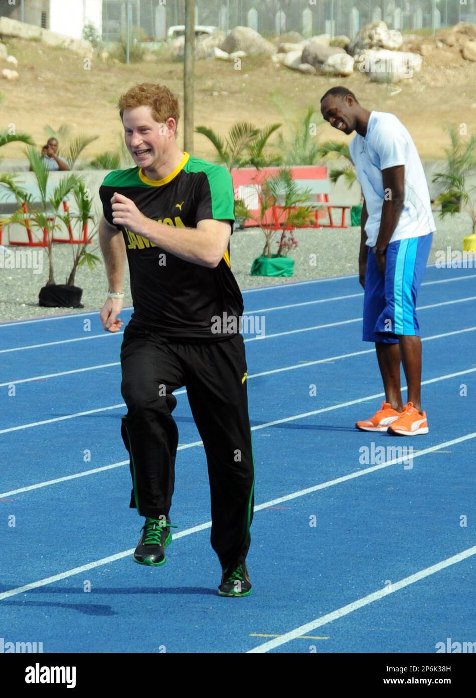 Britain's Prince Harry runs as Olympic sprint champion Usain Bolt ...