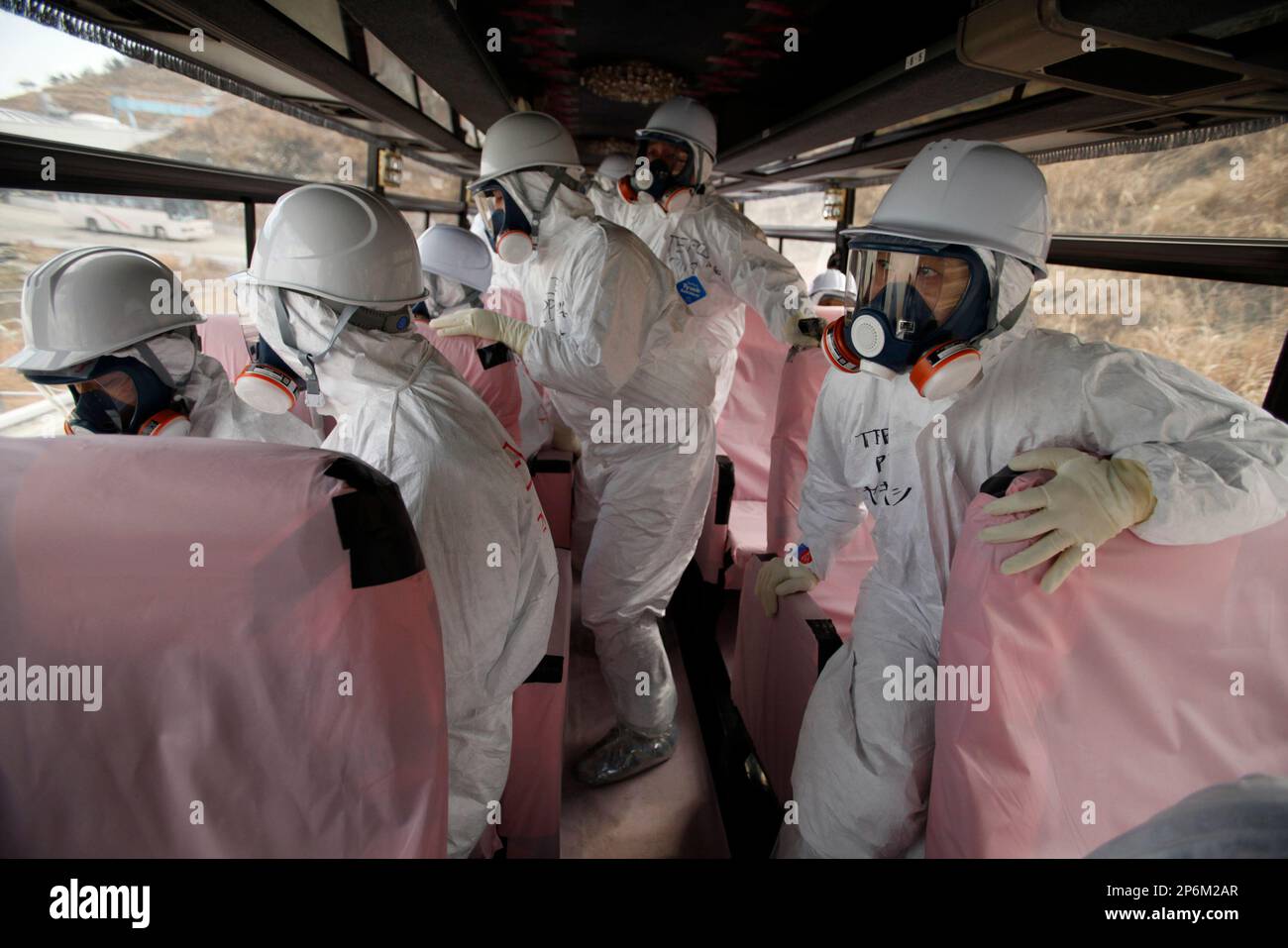 Officials from the Tokyo Electric Power Co. and members of media look ...