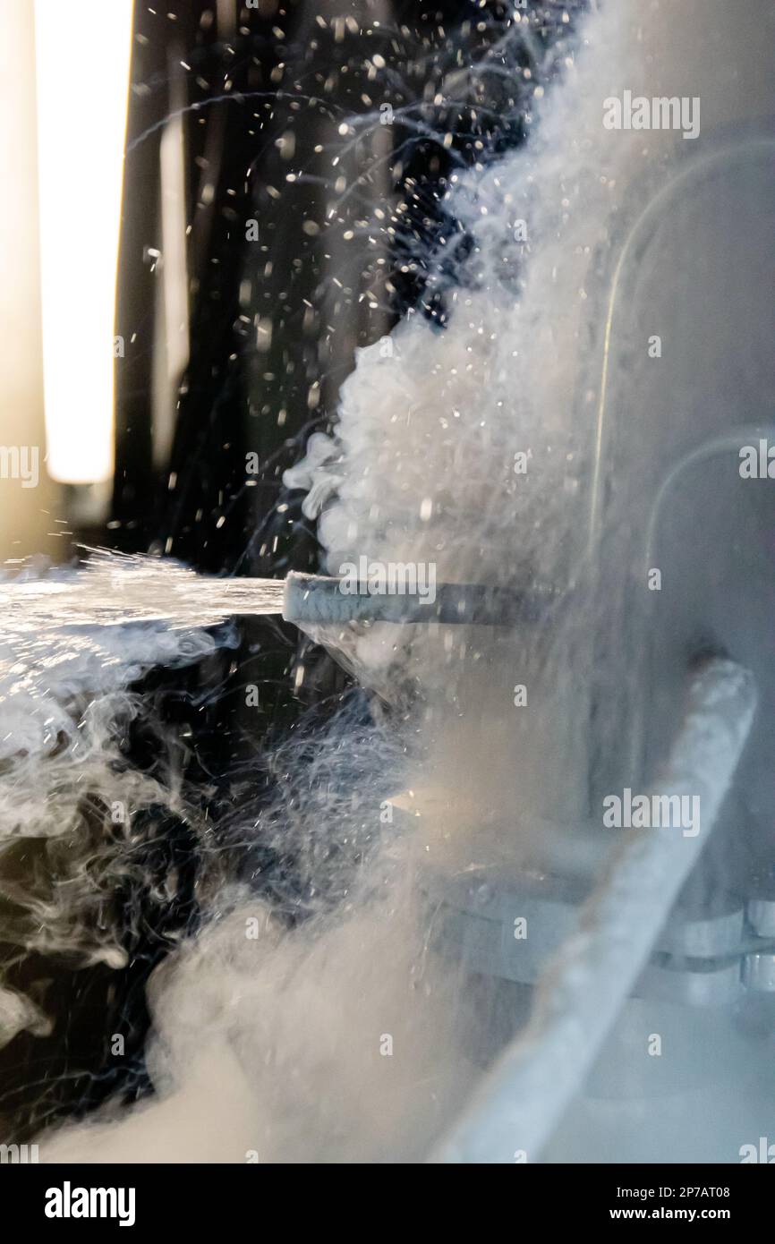 De l'azote liquide éclabousse le long du gaz émanant du tuyau en ...