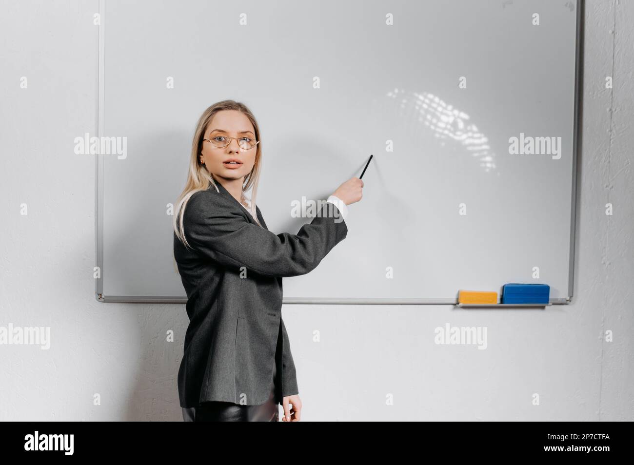 un jeune enseignant écrit sur le tableau, explique des exercices aux ...