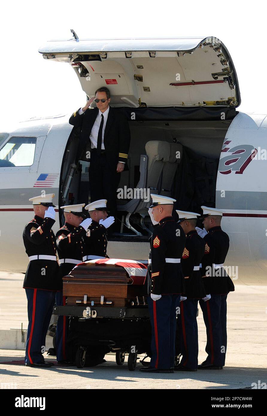 A detail of seven Marines and a pilot salute the casket of Marine Cpl ...