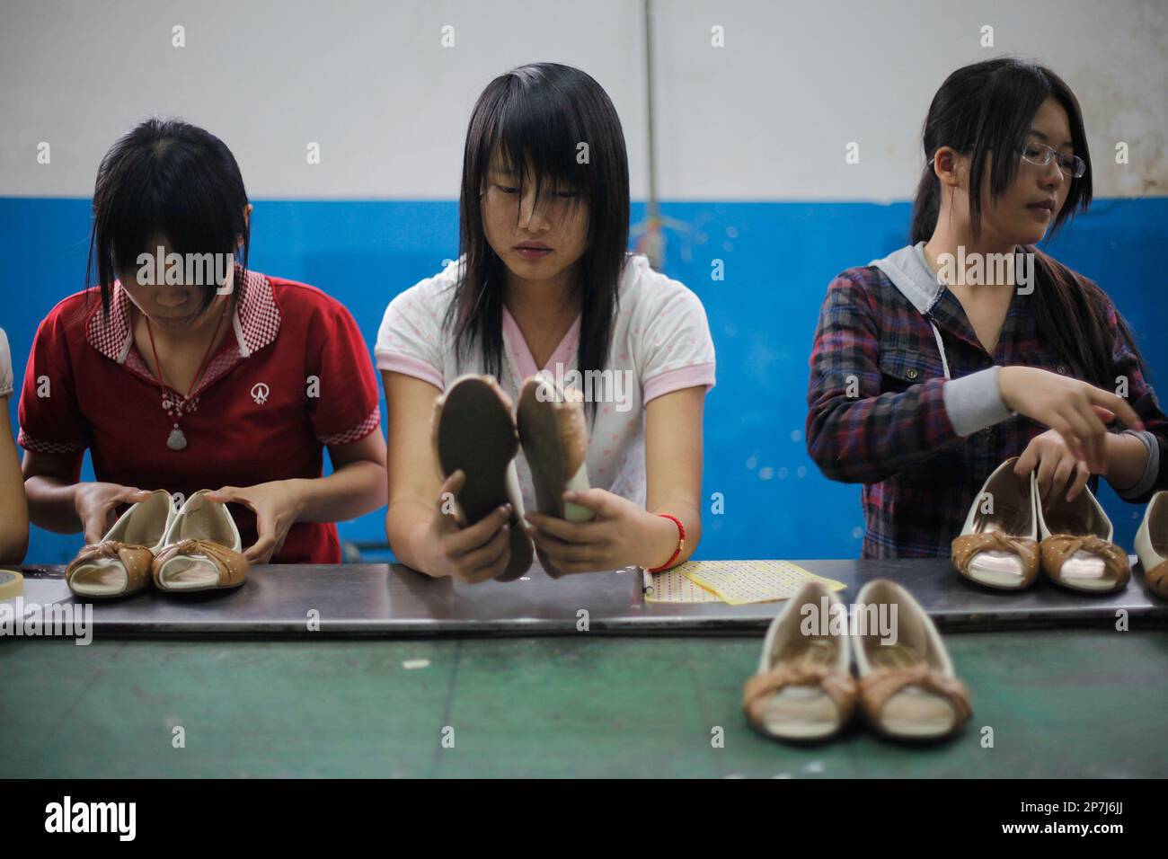 Employees make female shoes for export at the Runqiang Shoe Factory in ...
