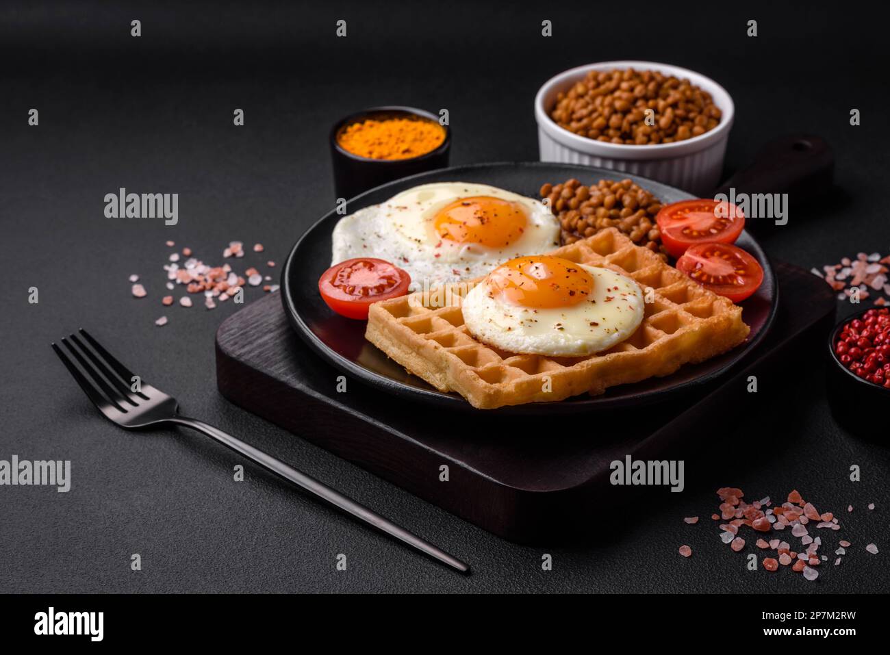 Délicieux petit déjeuner copieux composé d'un œuf frit, de gaufres ...