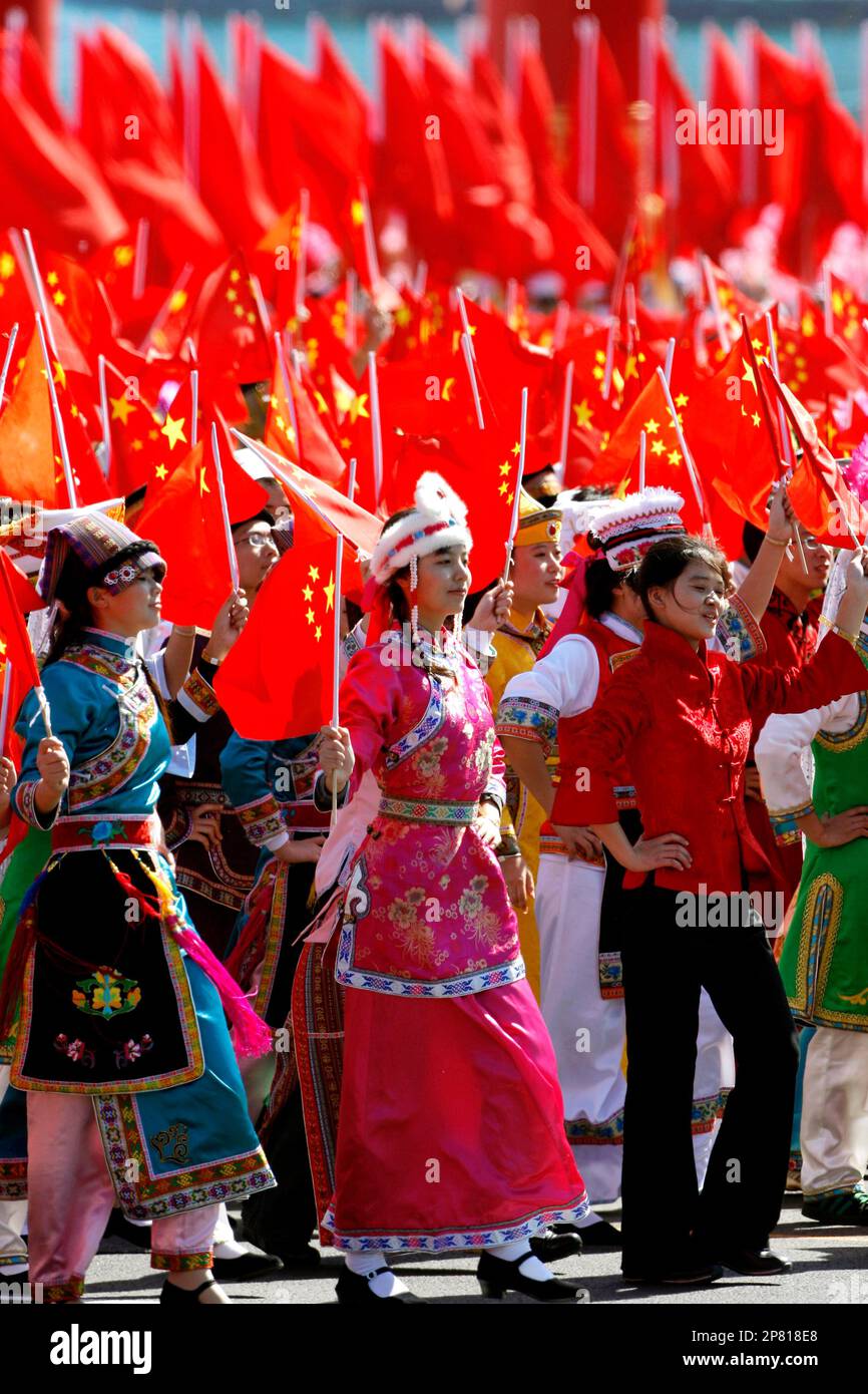 Chinese dress in local costume waves Chinese flags as they march past ...