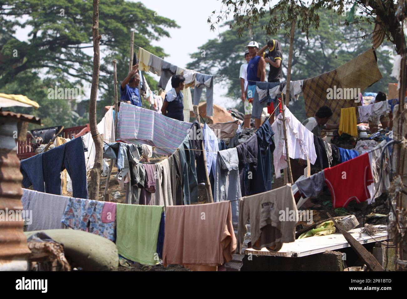 Laundered clothes are hung to dry after they were soiled with mud ...