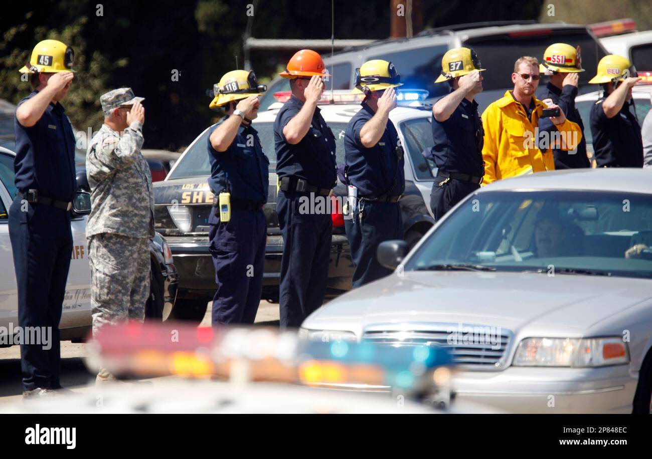 Firefighters and law enforcement officials line up at the Station fire ...