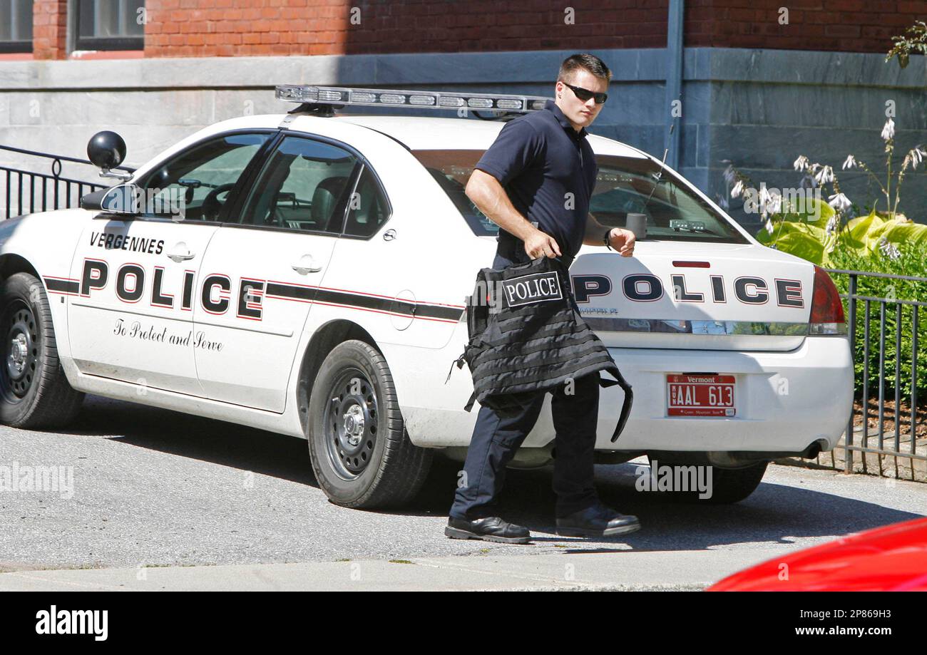 A police officer walks past his cruiser in Vergennes, Vt., Friday, Aug ...