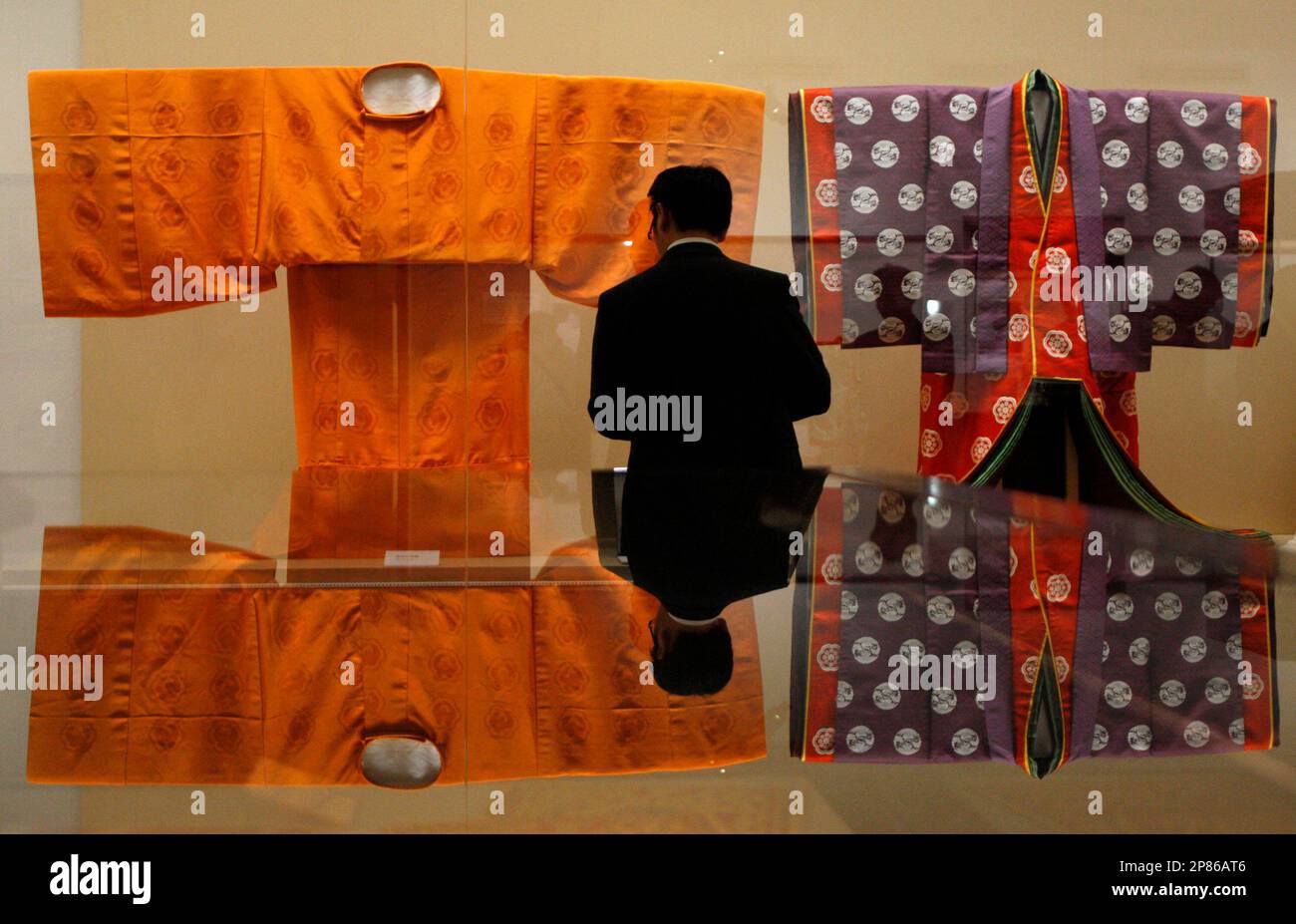 A reporter looks at traditional wedding robes worn by Japan's Emperor ...