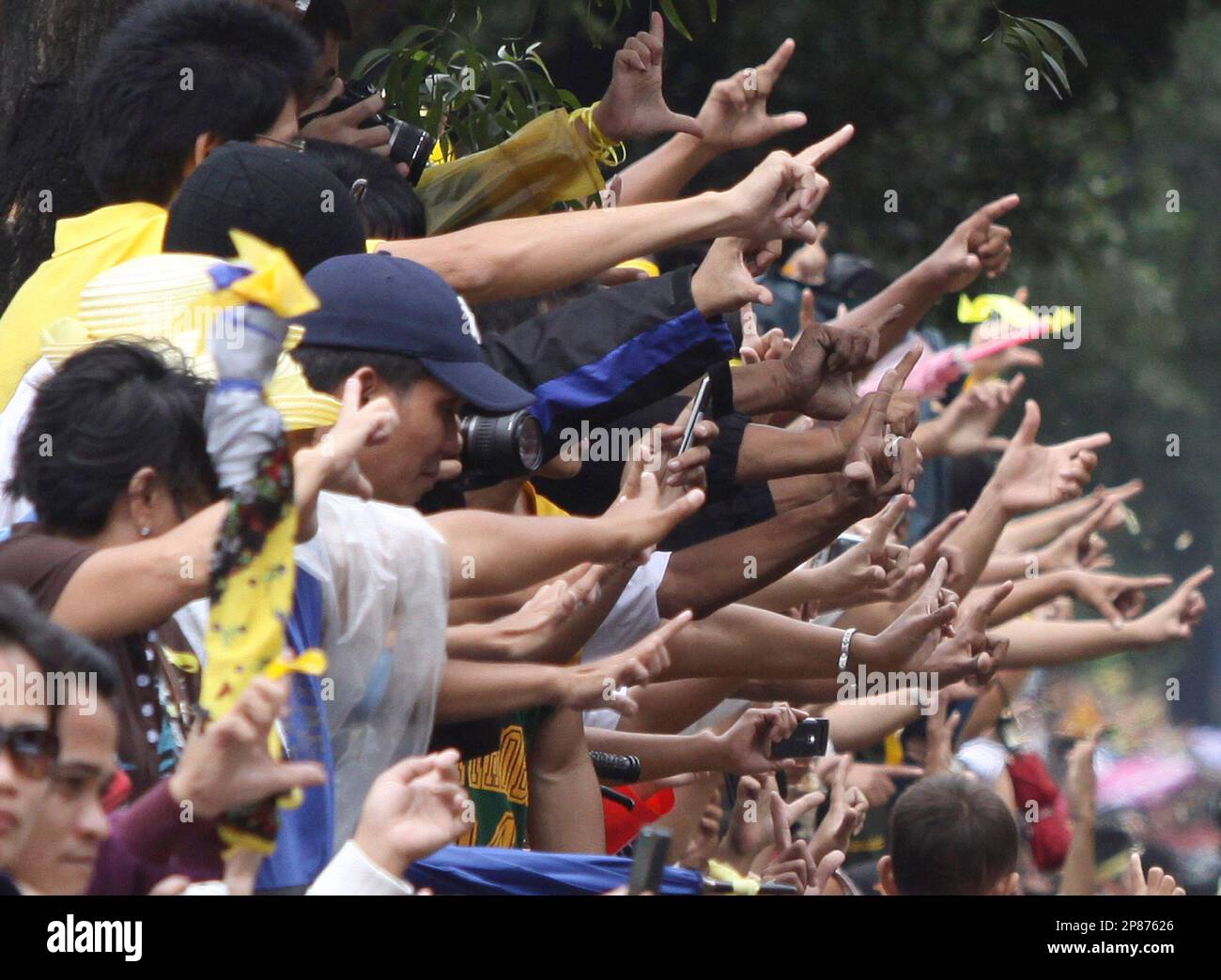 Filipinos flash the "laban" sign, which means "fight" as the funeral ...
