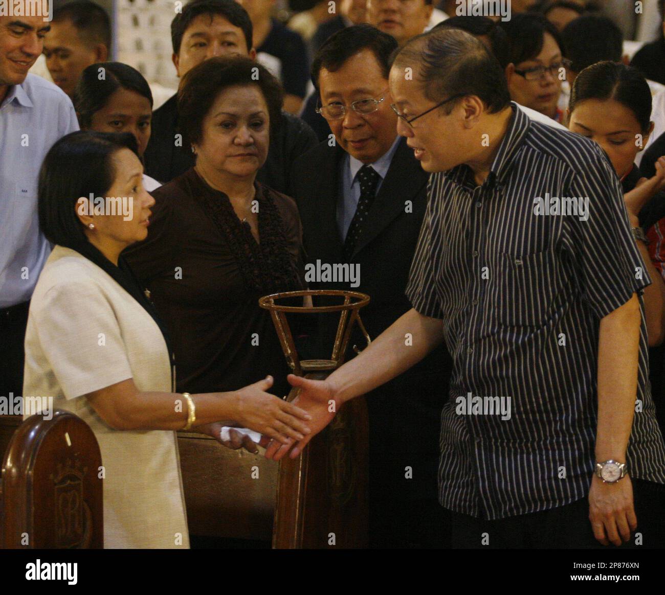 Philippine President Gloria Macapagal Arroyo, left, expresses her condolences to Benigno "Noynoy ...