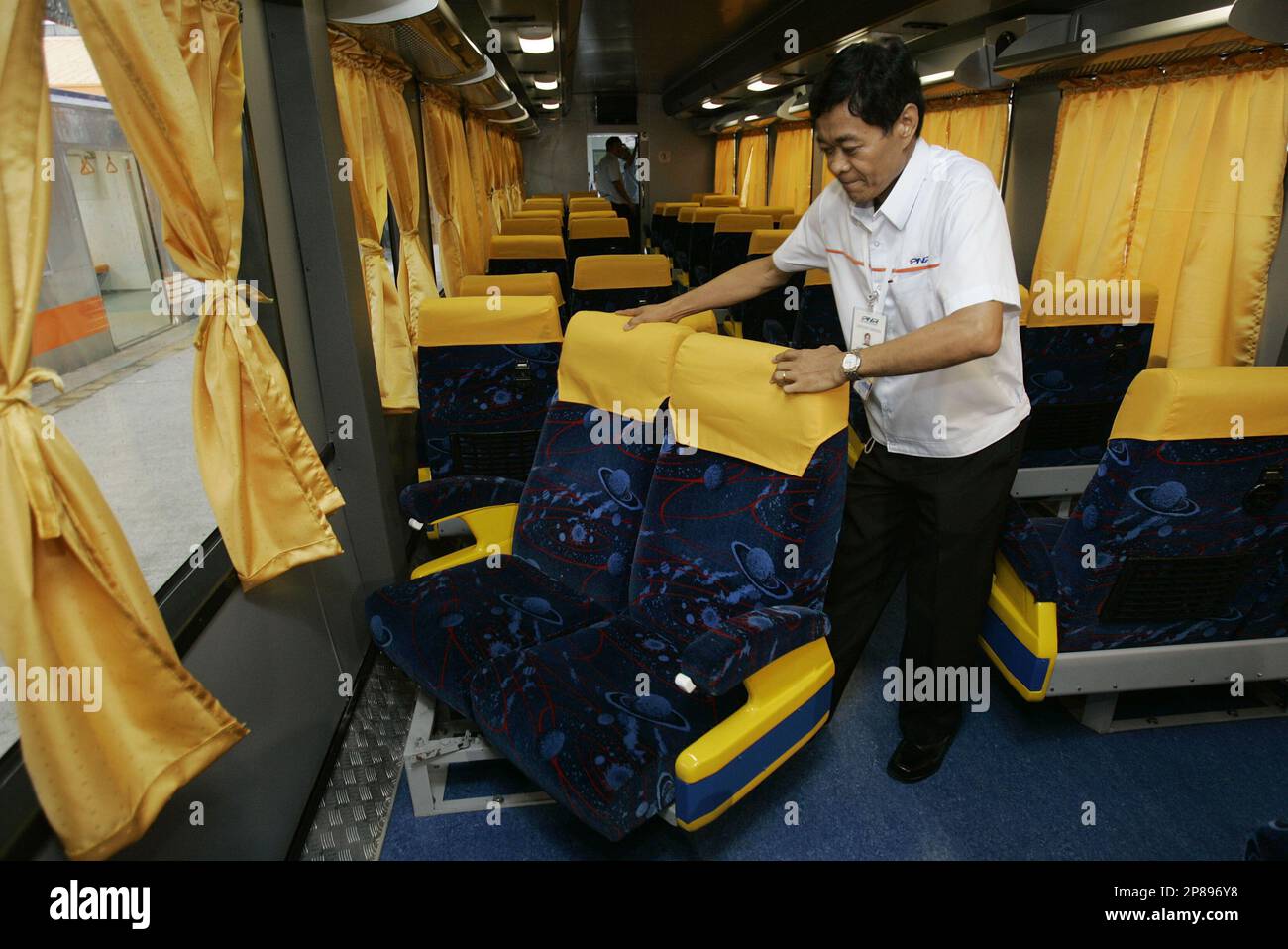 An employee of the Philippine National Railways shows rotating seats of ...