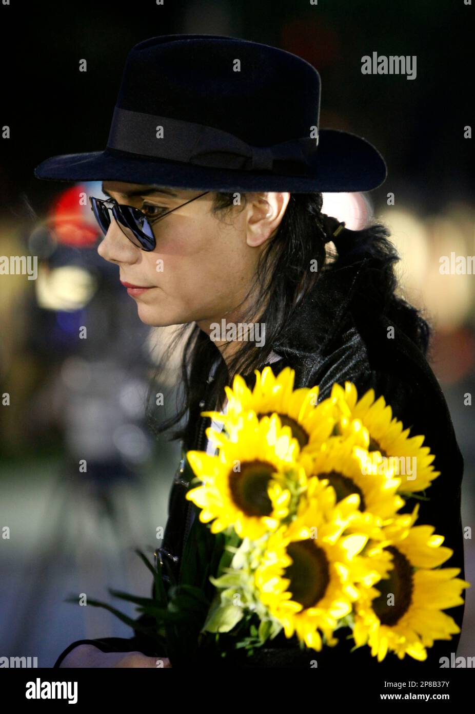 A fan of Michael Jackson holds flowers during a vigil in Mexico City ...