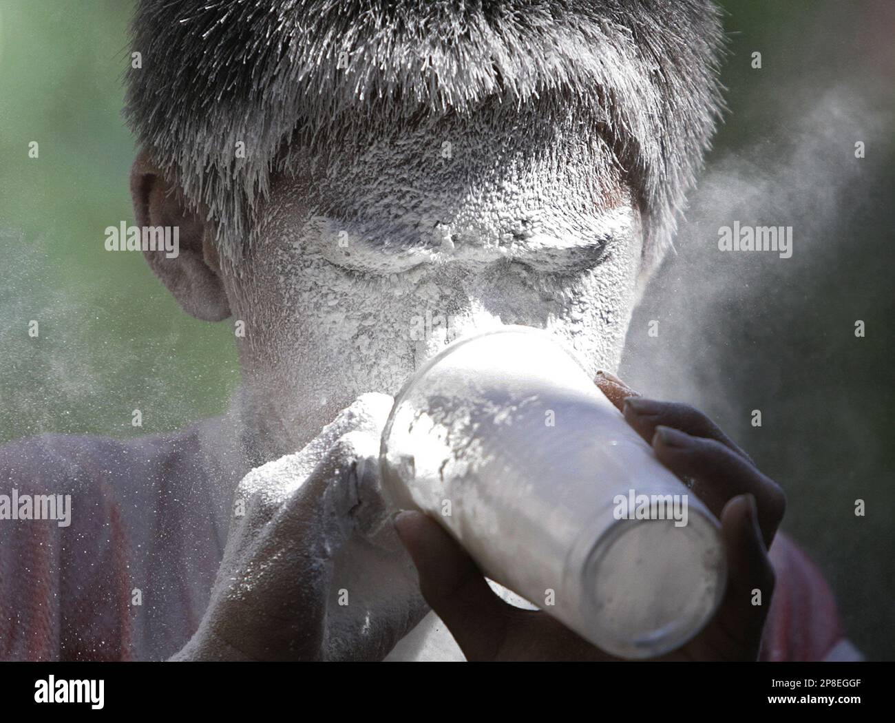 A Filipino boy races to blow powder out of a plastic cup using a straw ...