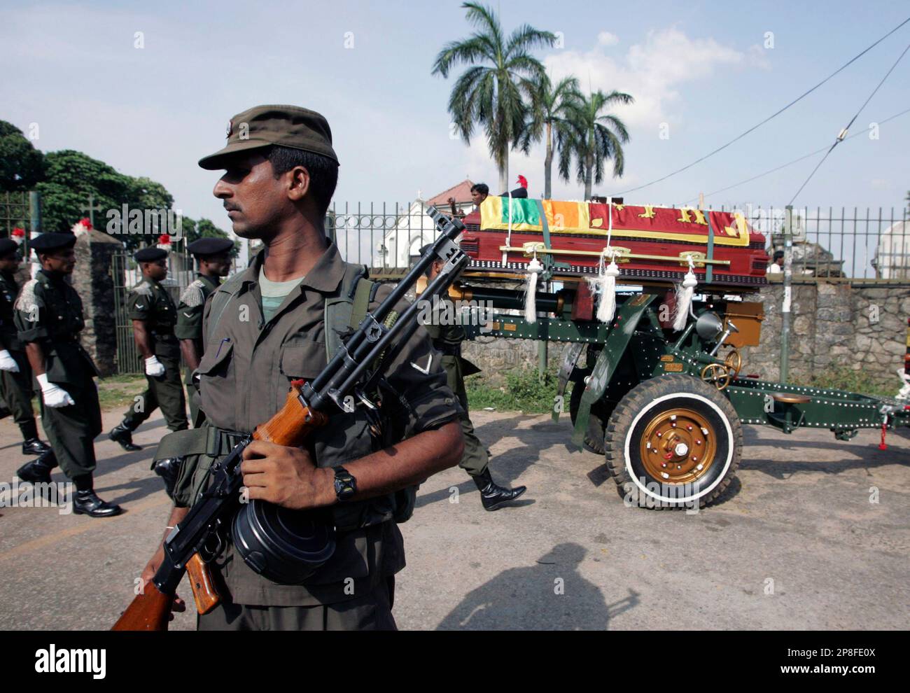 A Sri Lankan army soldier stands guard as others march during the ...