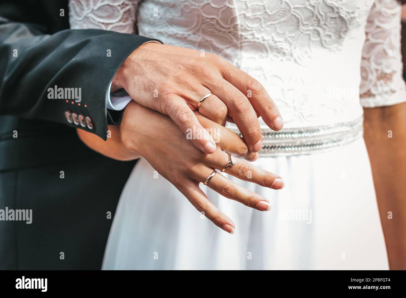 Photo en gros plan des mains de la mariée et du marié, ornée d'anneaux ...