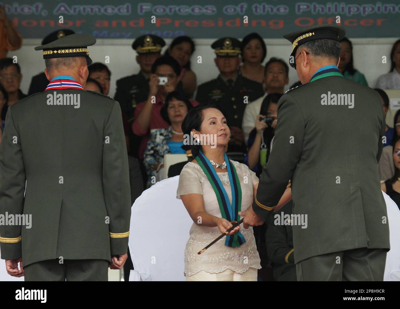 Philippine President Gloria Macapagal Arroyo, center, hands the saber ...