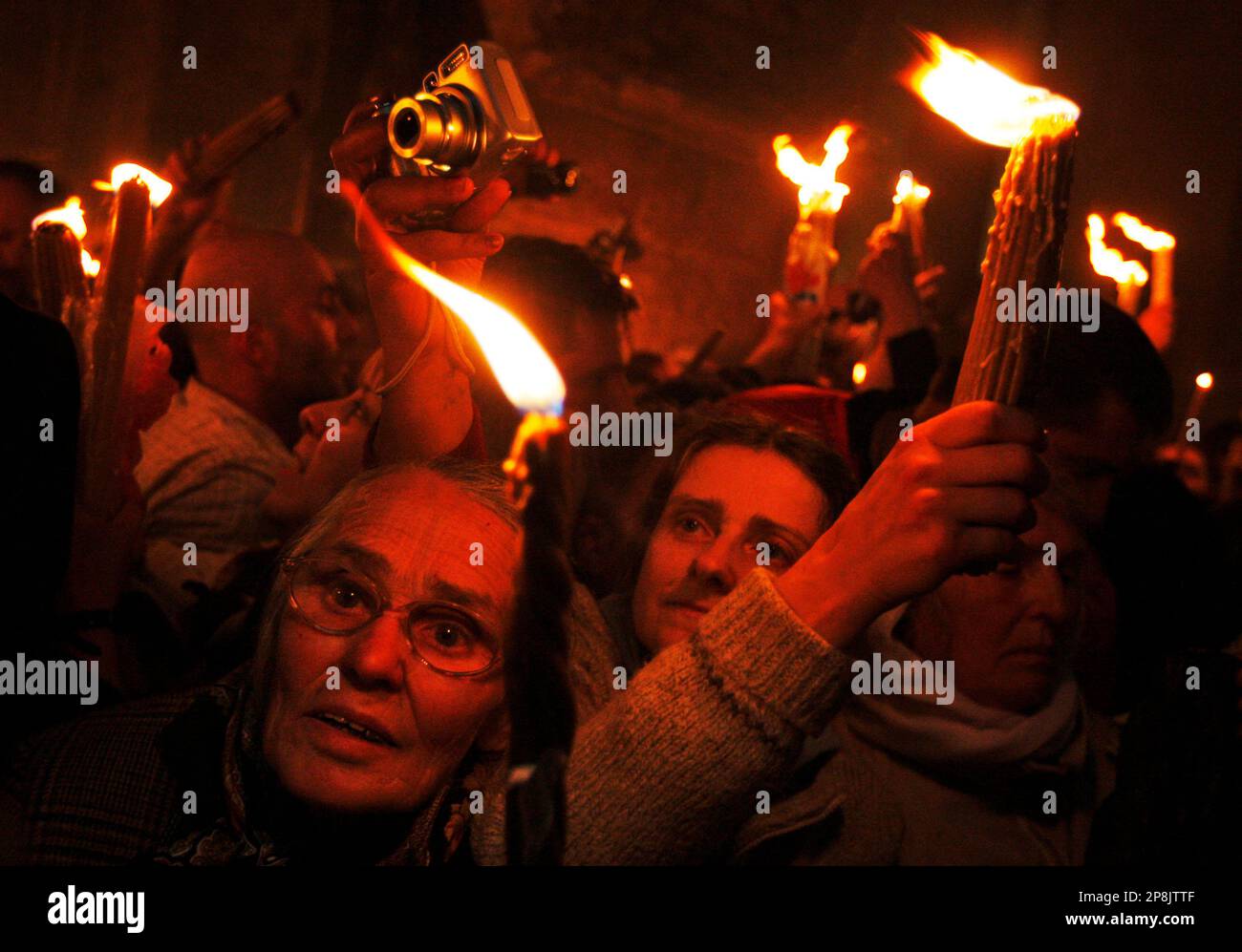 Christian Orthodox pilgrims hold candles in the Church of the Holy ...