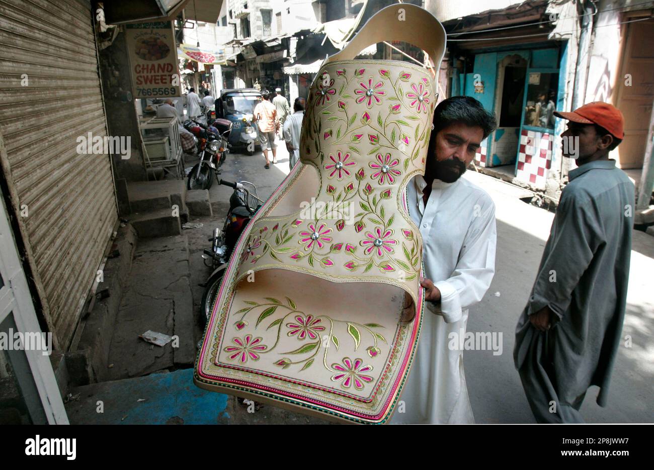 A Pakistani Abdul Hafeez carries a huge traditional embroidered shoe ...