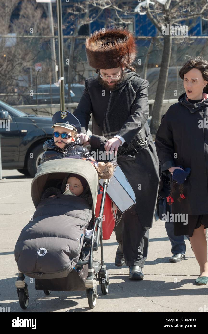 Une famille juive orthodoxe célèbre Purim, le père en portant son ...