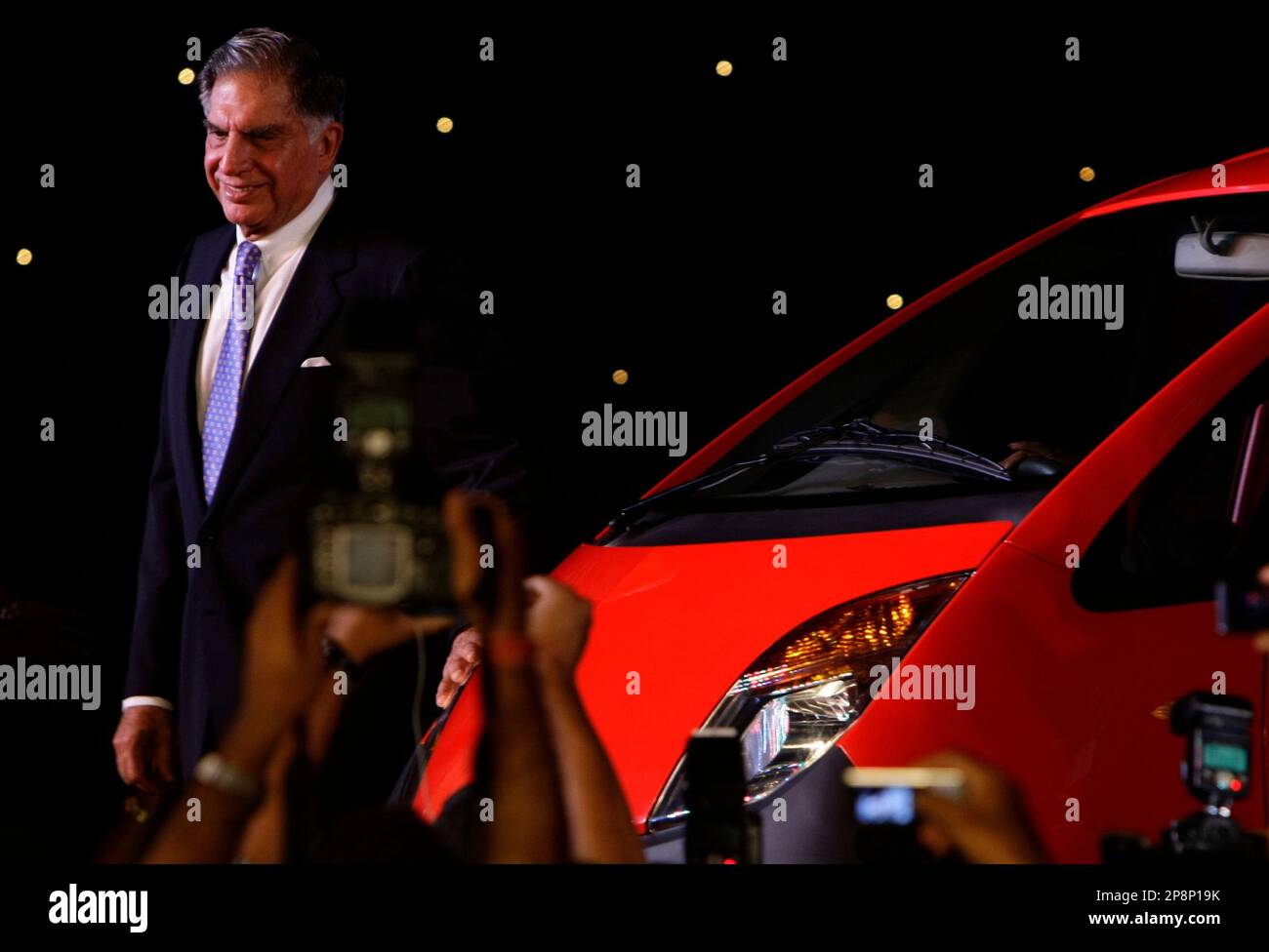 Tata Sons Chairman Ratan Tata poses alongside the Tata Nano at its ...