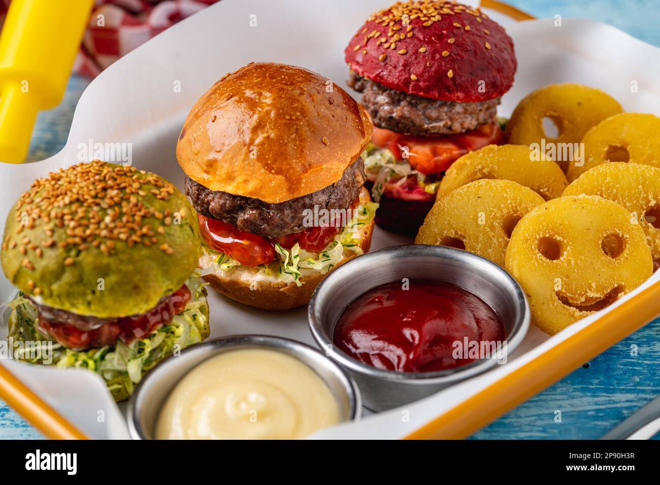 trois mini-hamburgers avec poulet et viande servis avec des frites ...