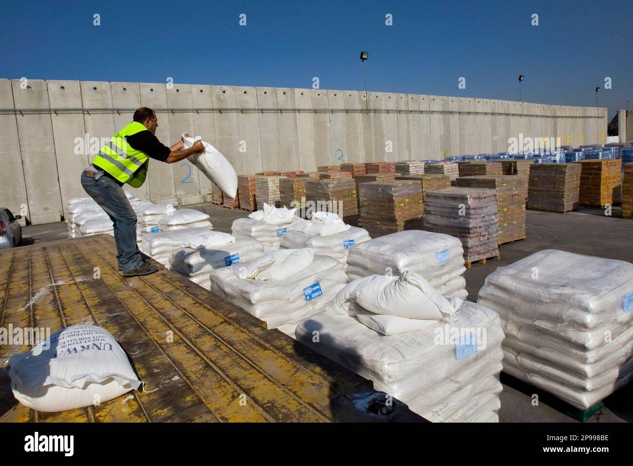 An Israeli worker moves a bag of UN humanitarian aid bound for Gaza, on ...