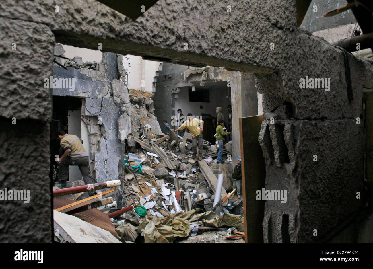 Palestinians inspect the rubble of a building used by the security ...