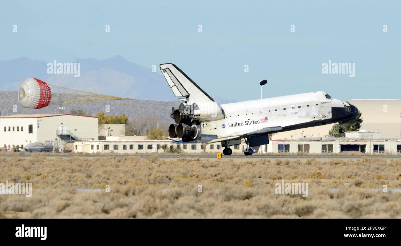 A parachute deploys as the space shuttle Endeavour touches down at Edwards Air Force Base ...