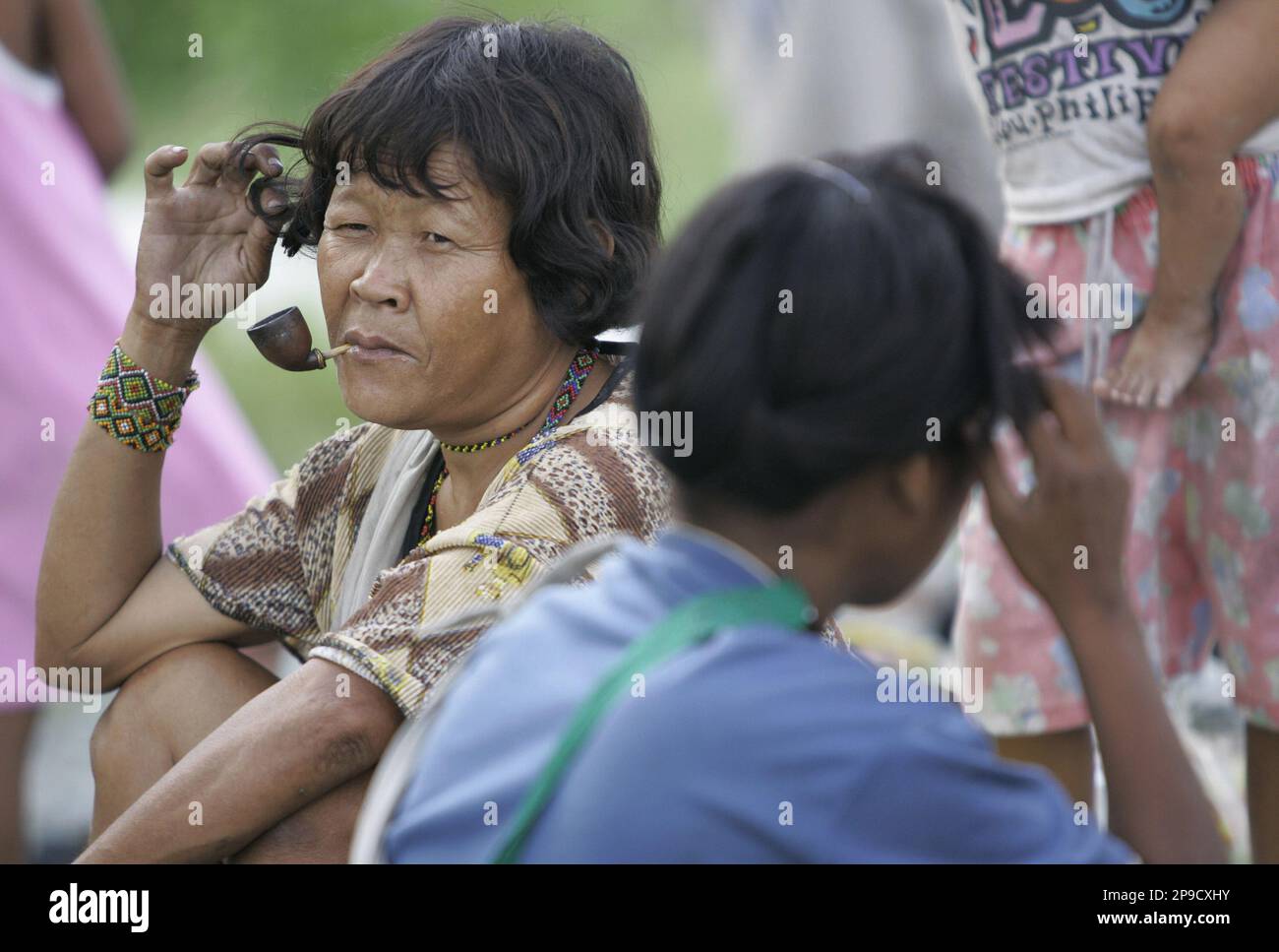 Filipino Mangyan tribe people from Oriental Mindoro, central Philippines, smoke a pipe as they ...