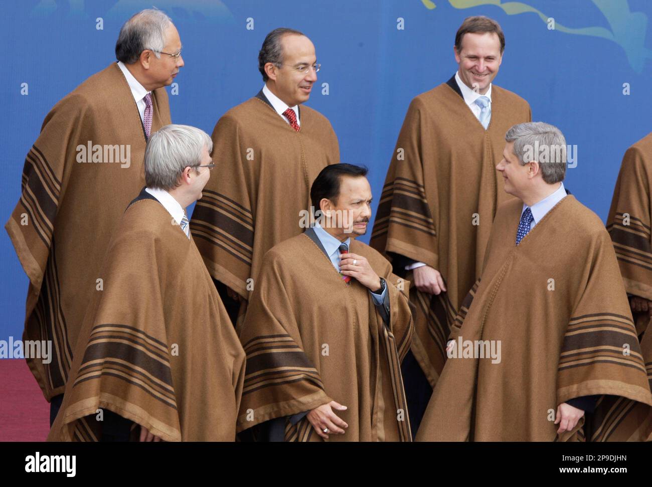 Brunei's Sultan Haji Hassanal Bolkiah, bottom center, fixes his tie as ...