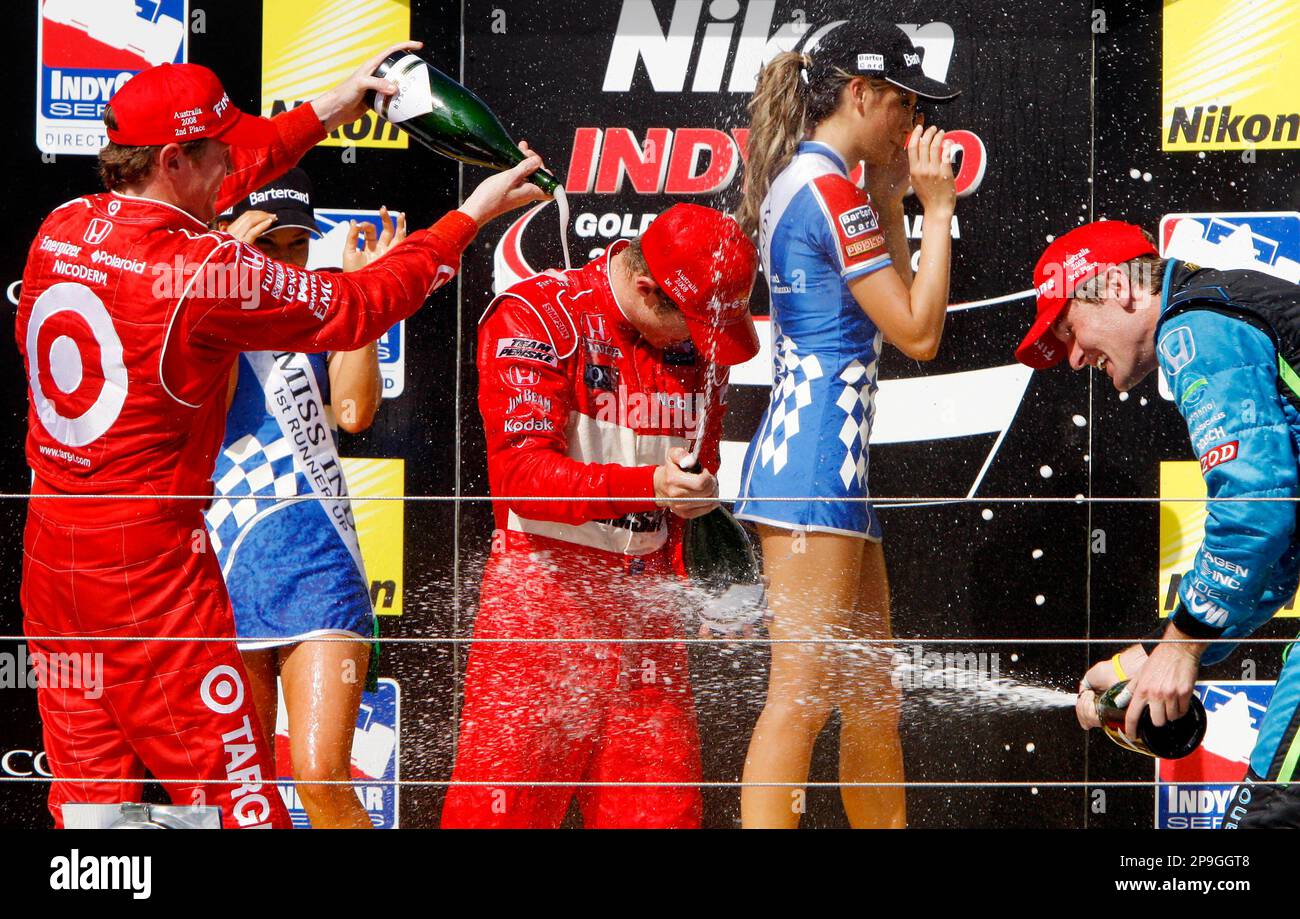 Team Penske driver Ryan Briscoe of Australia, center, is showered with ...