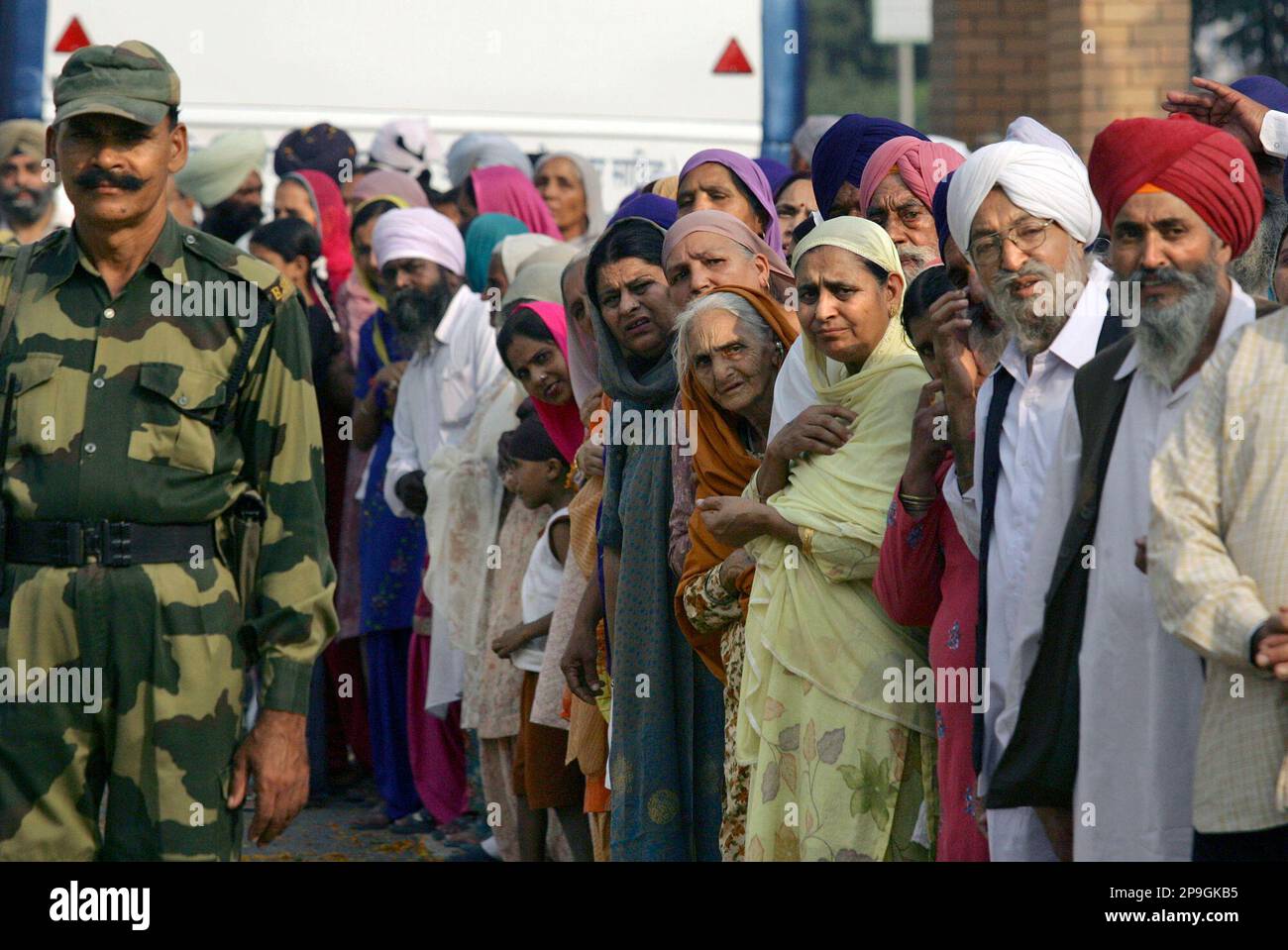 An Indian Border Security Force personnel stands guard as Sikh devotees ...