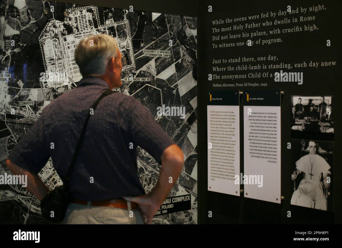 A visitor looks at an exhibit showing wartime Pope Pius XII on display ...