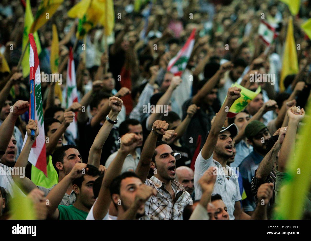 Hezbollah supporters raise up their hands as they shout pro-Hezbollah ...