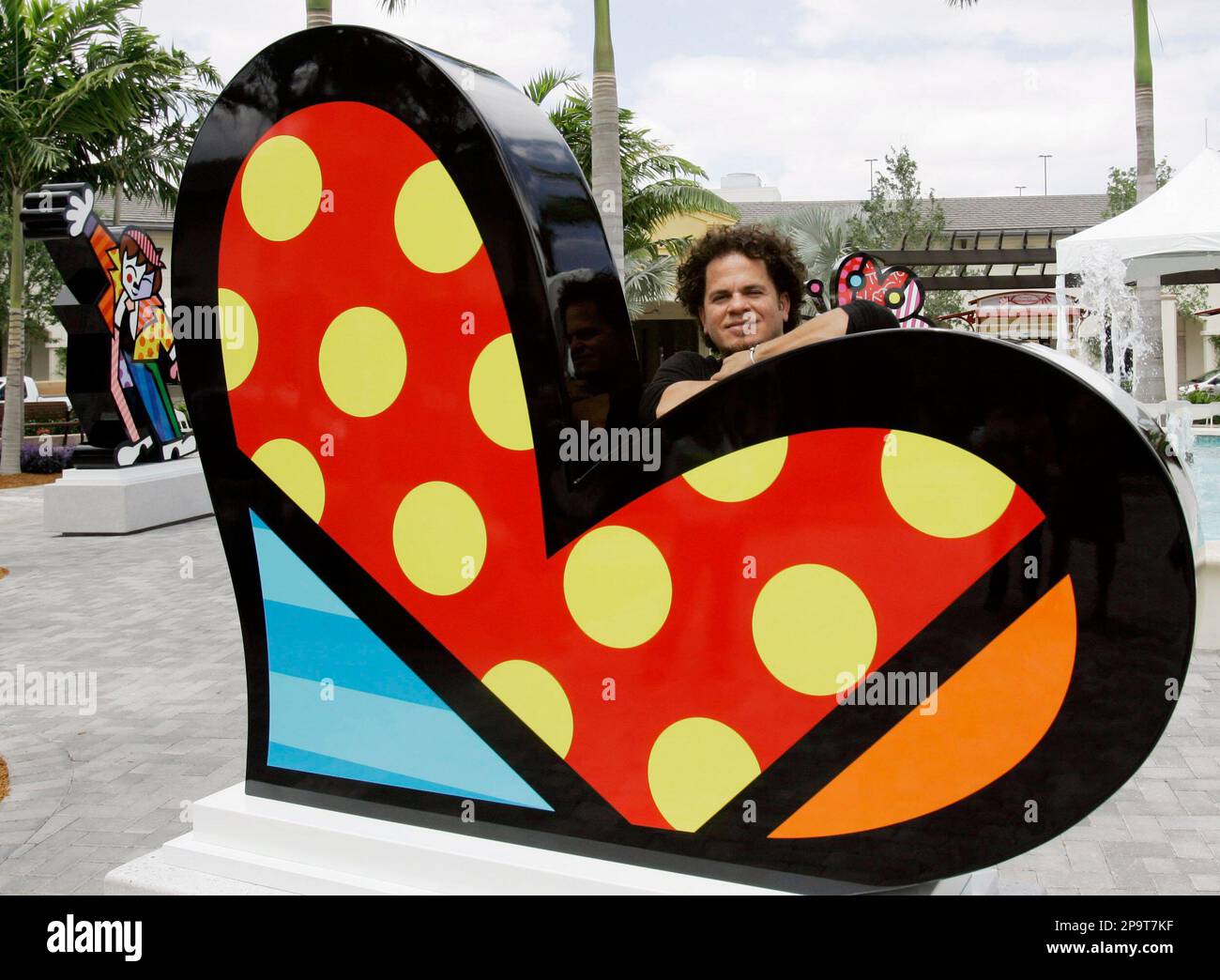 Brazilian artist Romero Britto poses for photos next to his sculpture ...