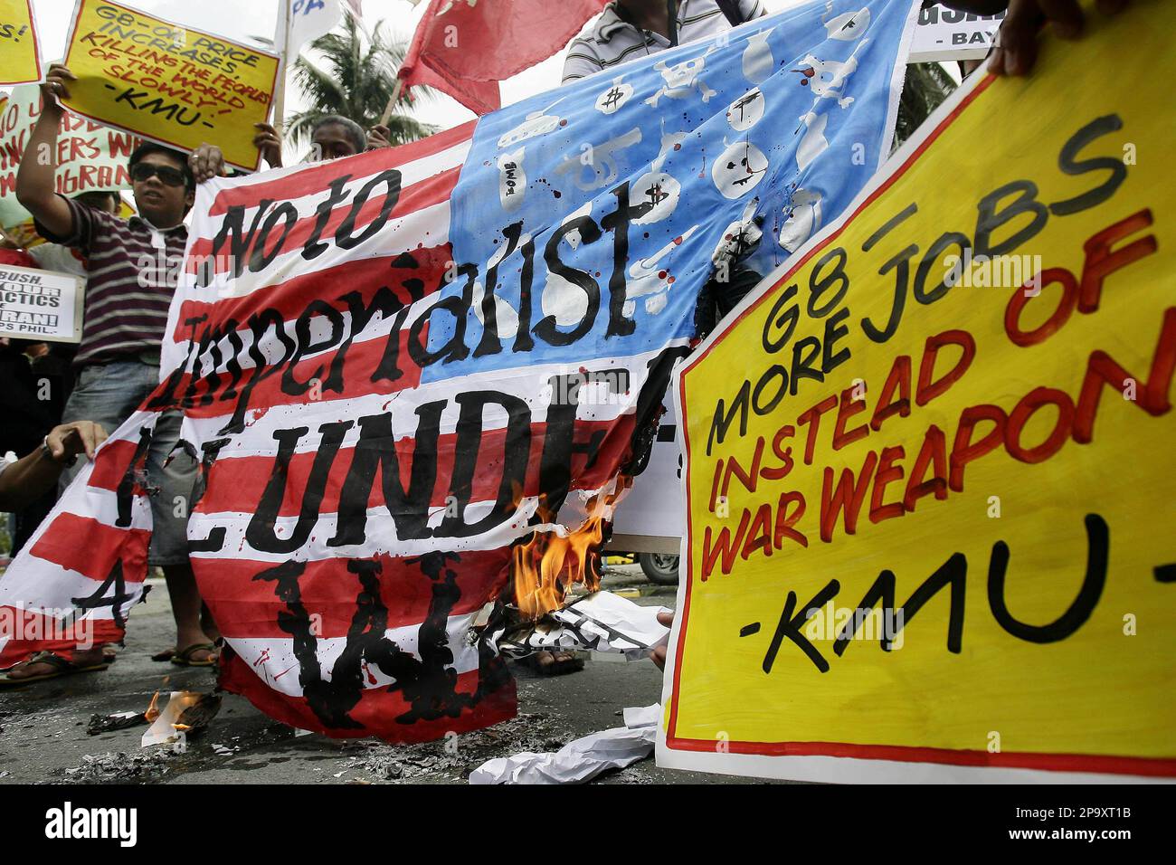 Anti-G8 Filipino protesters burn a U.S. flag bearing slogans in front ...