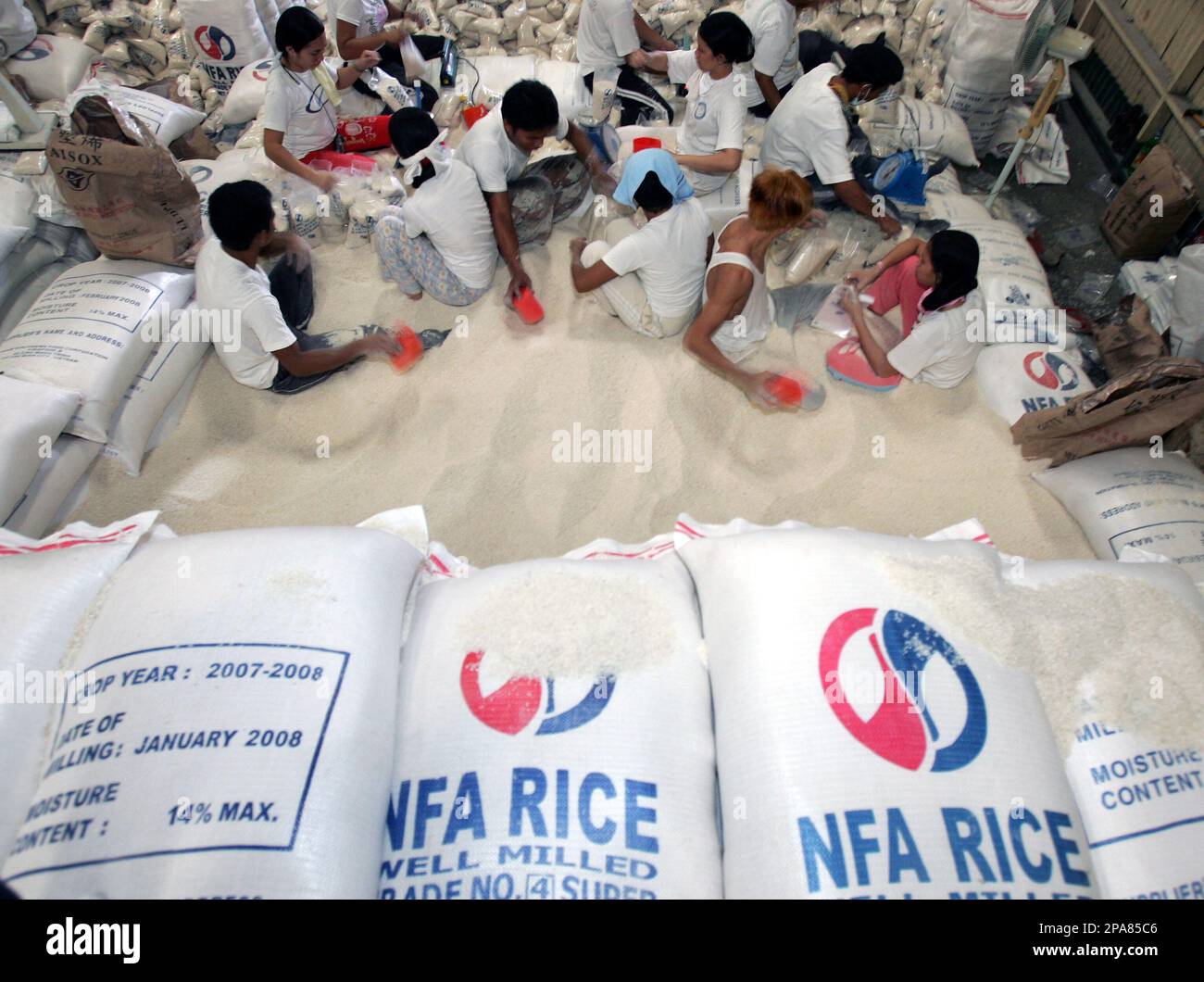 Workers repack imported rice to be sold to poor residents at a ...