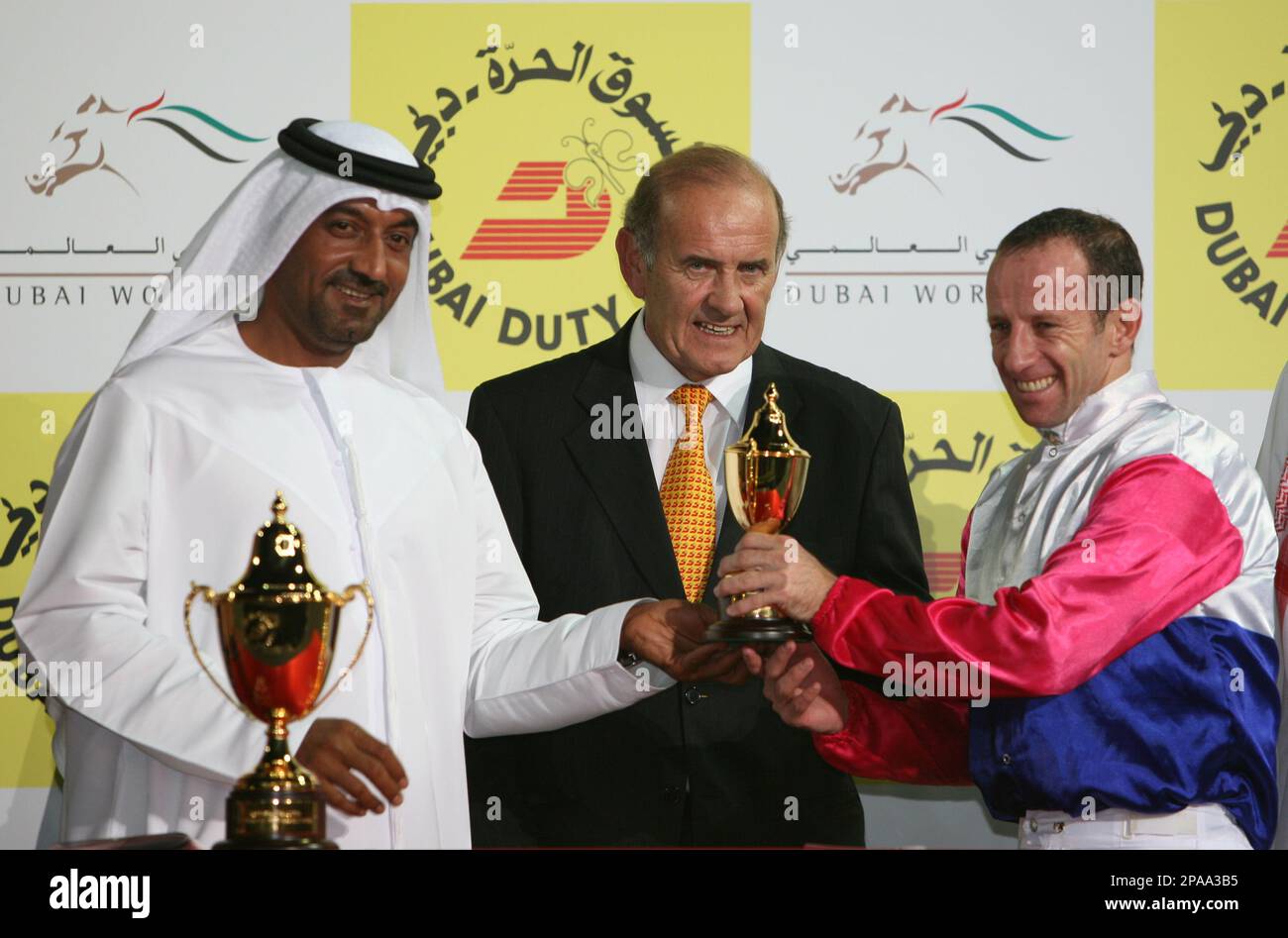 Jockey Anton Marcus, right, receives the trophy after winning the"Dubai ...
