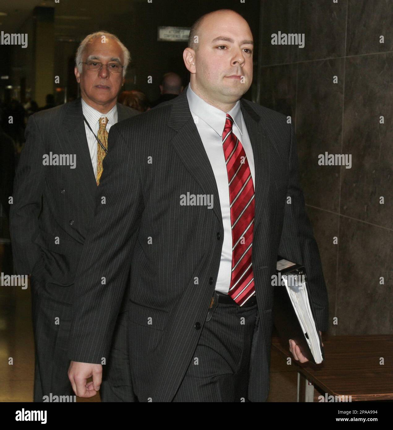 New York Police Detective James Valenti, foreground, is followed into ...