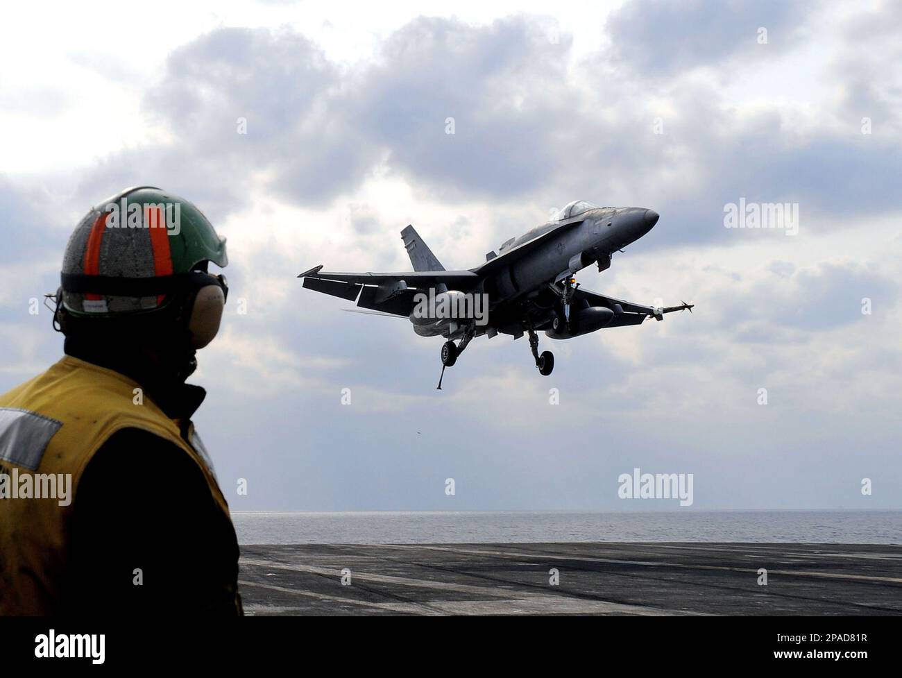 An F/A-18E/F Super Hornet lands on the nuclear-powered aircraft carrier ...