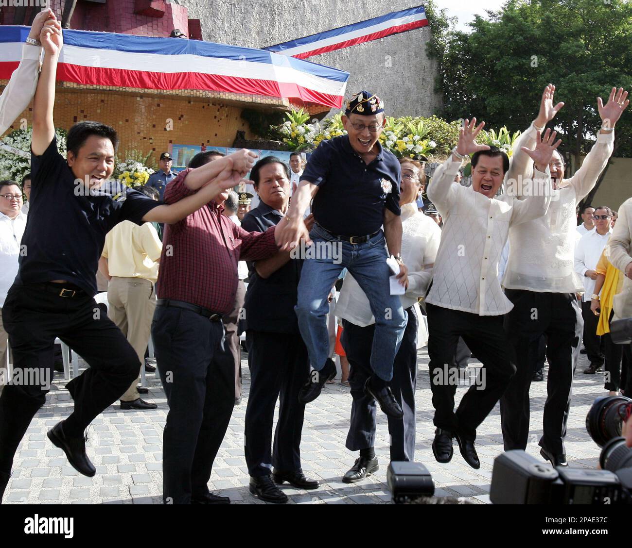 Former Philippine President Fidel V. Ramos, center, reenacts his famous jump 22 years ago, after ...