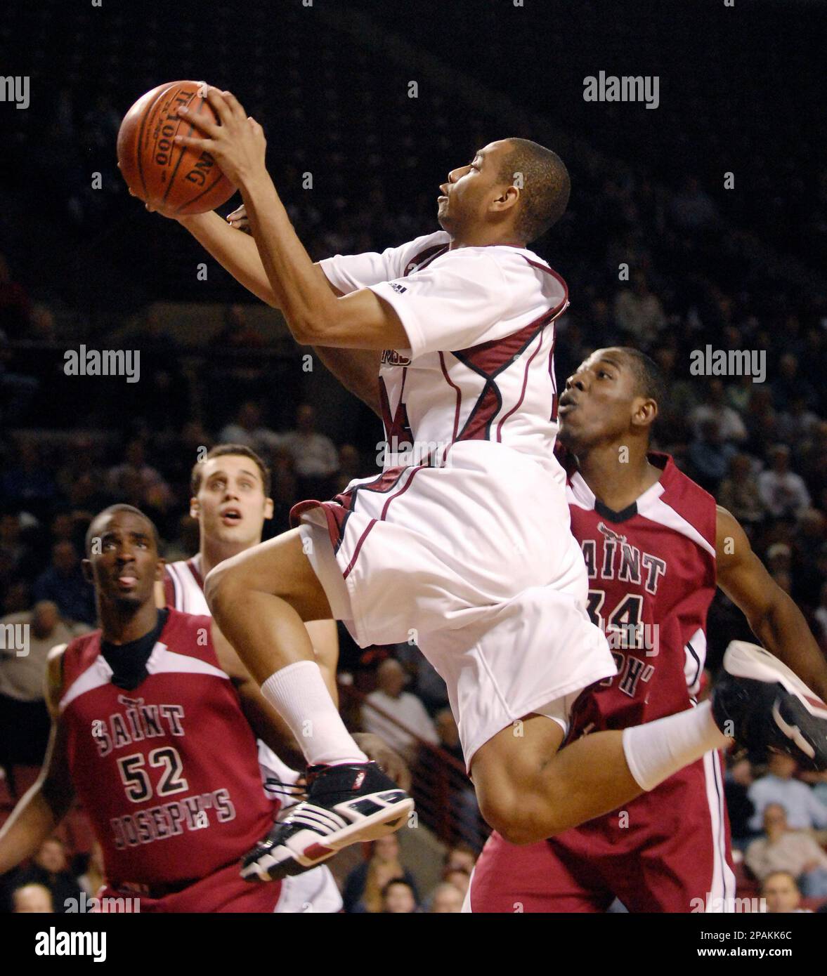 Massachusetts' Chris Lowe charges the basket against St. Joseph's Rob ...